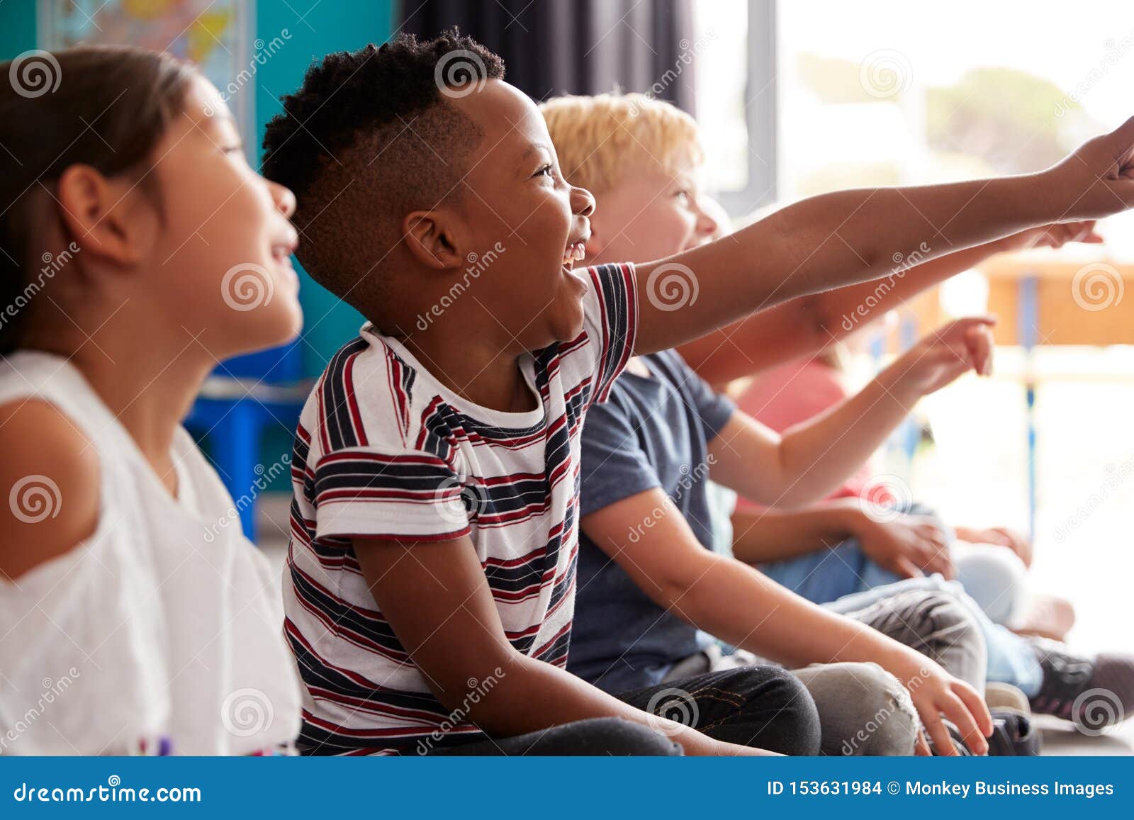 Group of Elementary School Pupils Sitting on Floor Listening To Teacher ... Group of Elementary School Pupils Sitting on Floor Listening To Teacher ...