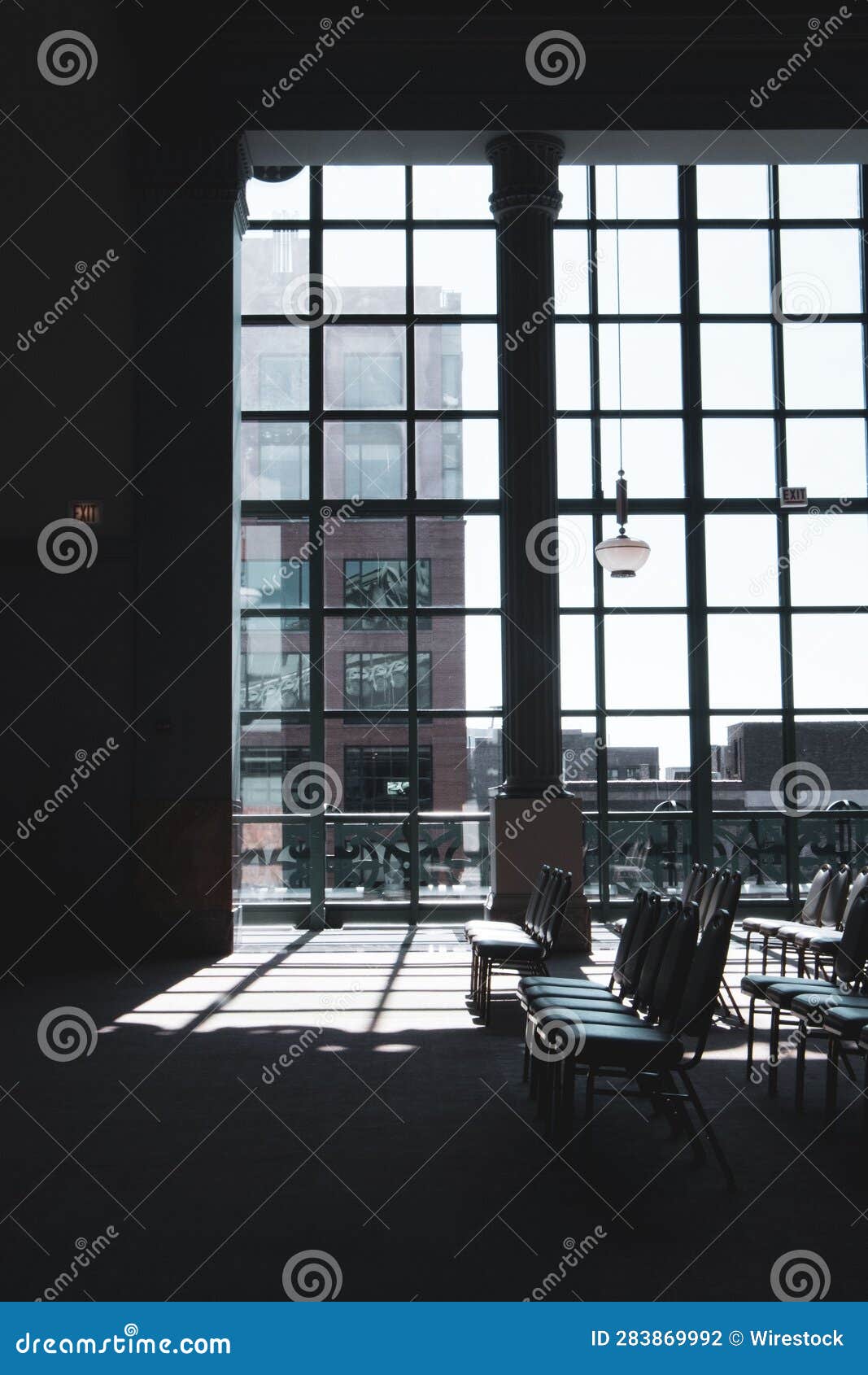 Group of Empty Chairs Sitting in Front of Tall Windows Stock Photo ...