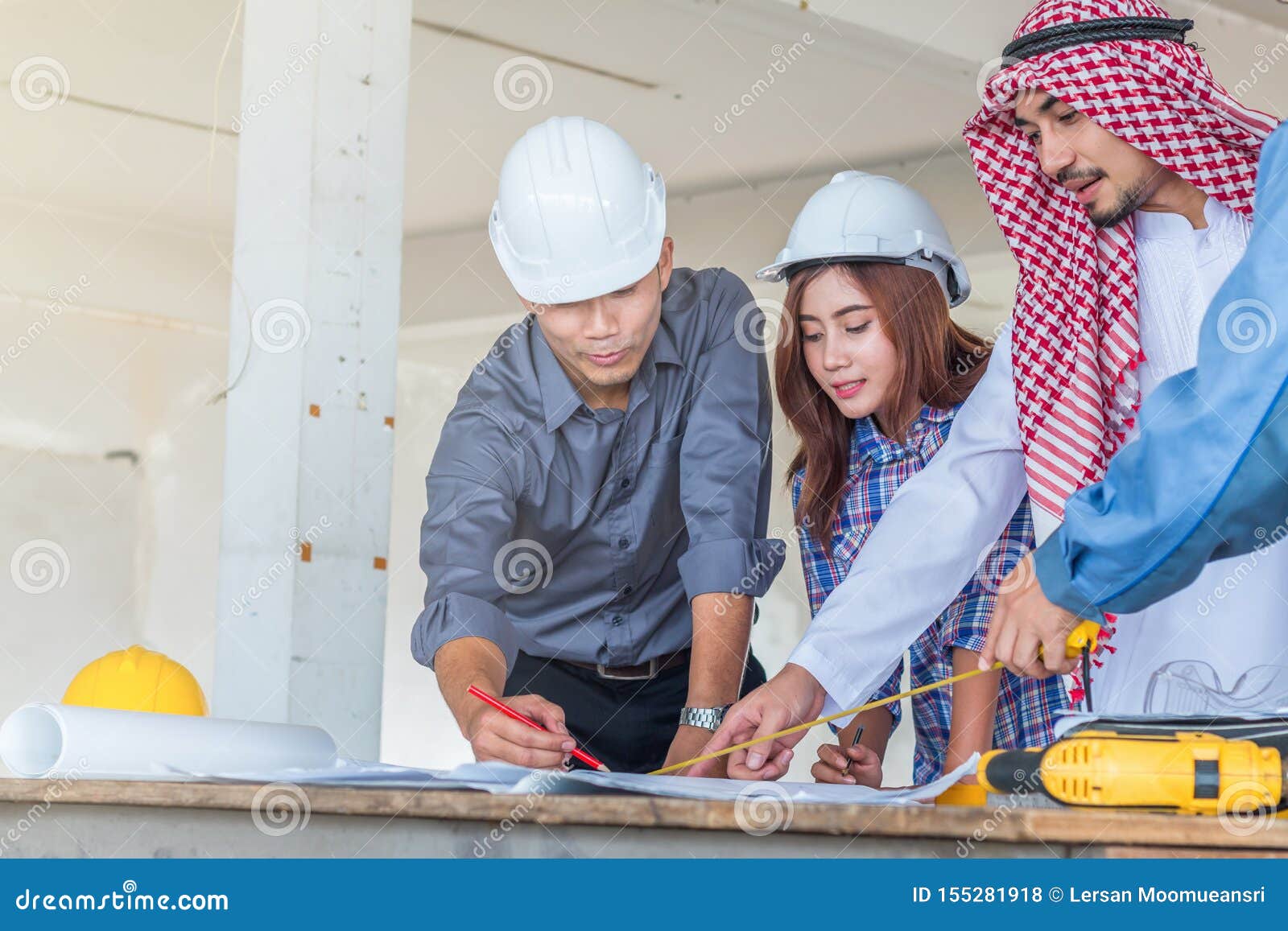 Group of Engineer and Arabian Checking the Blueprint on Table and ...
