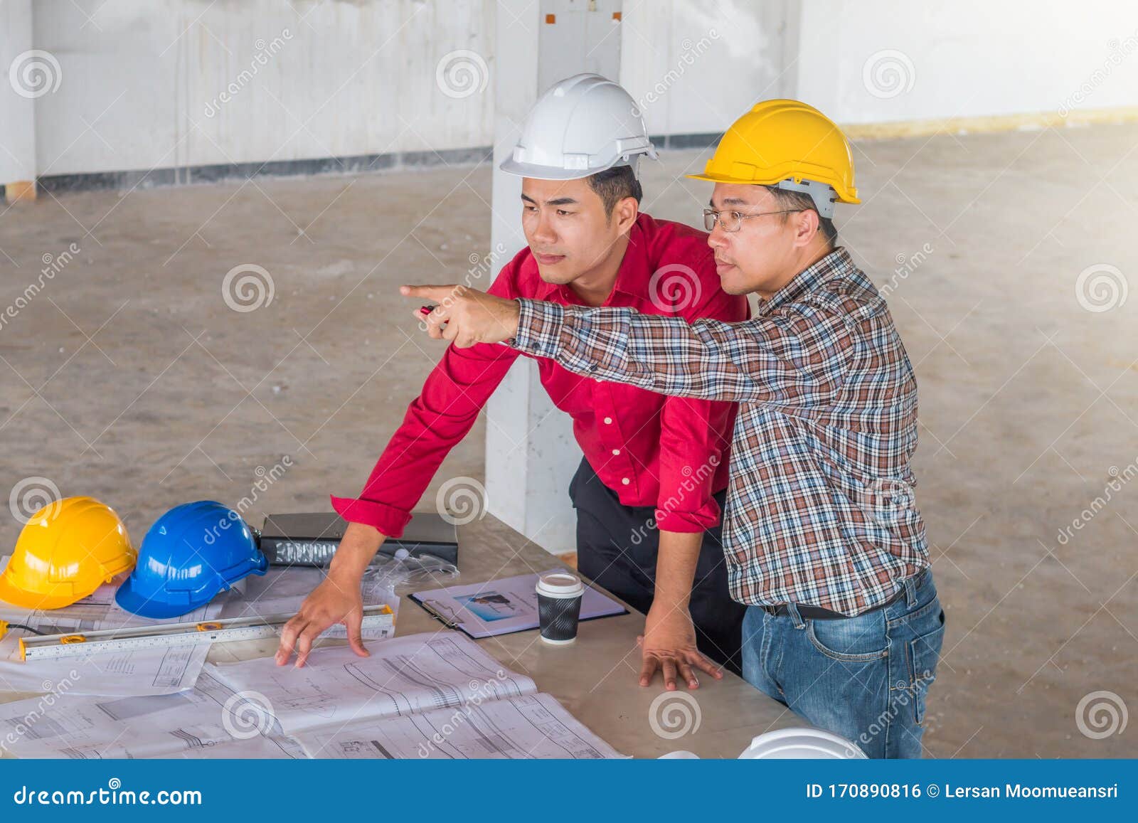 Group of Engineer Checking the Blueprint on the Table and Talking about ...