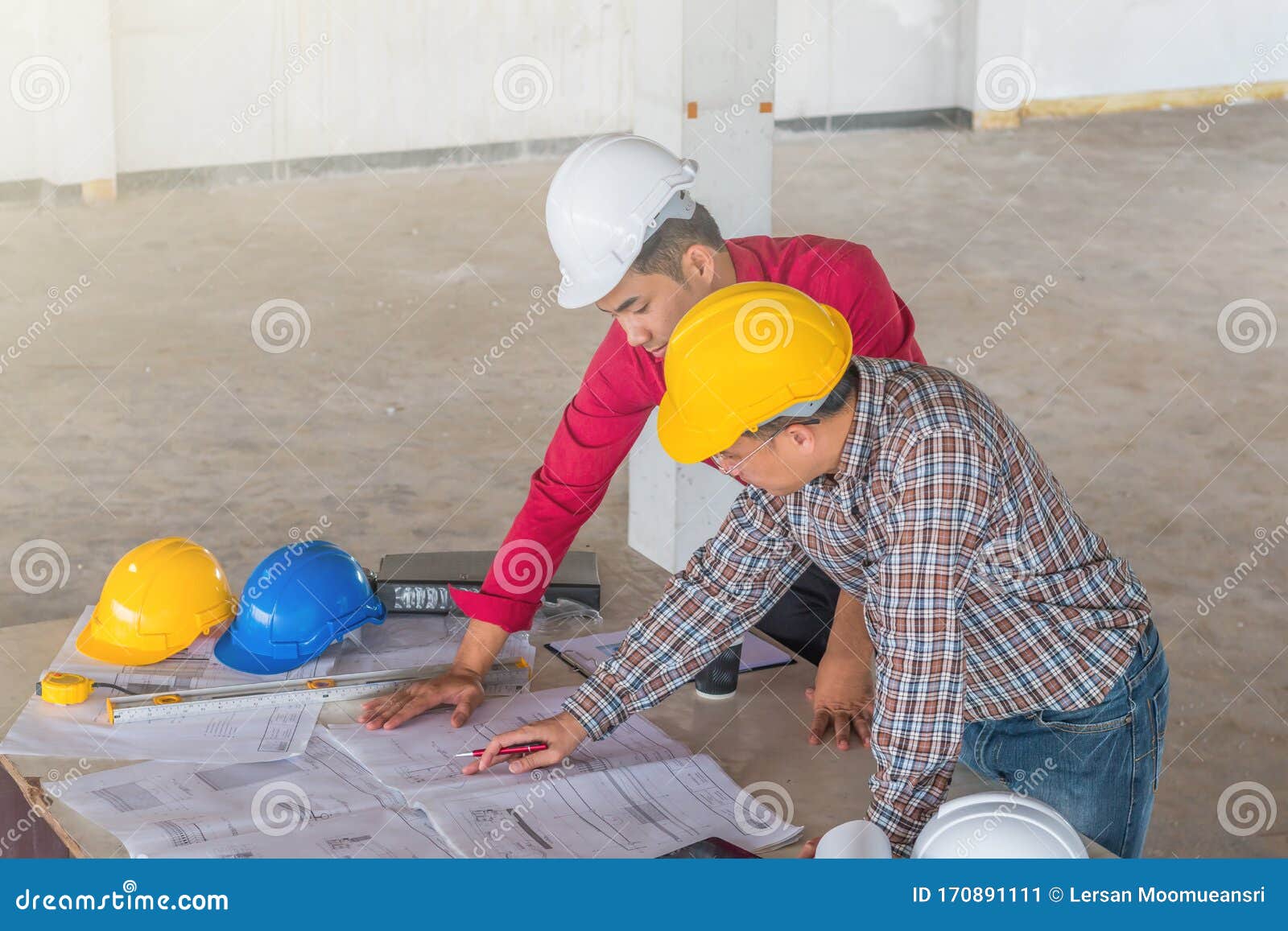 Group Of Engineer Checking The Blueprint On The Table And Talking About ...