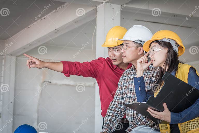 Group of Engineer Checking the Blueprint on the Table and Talking about ...