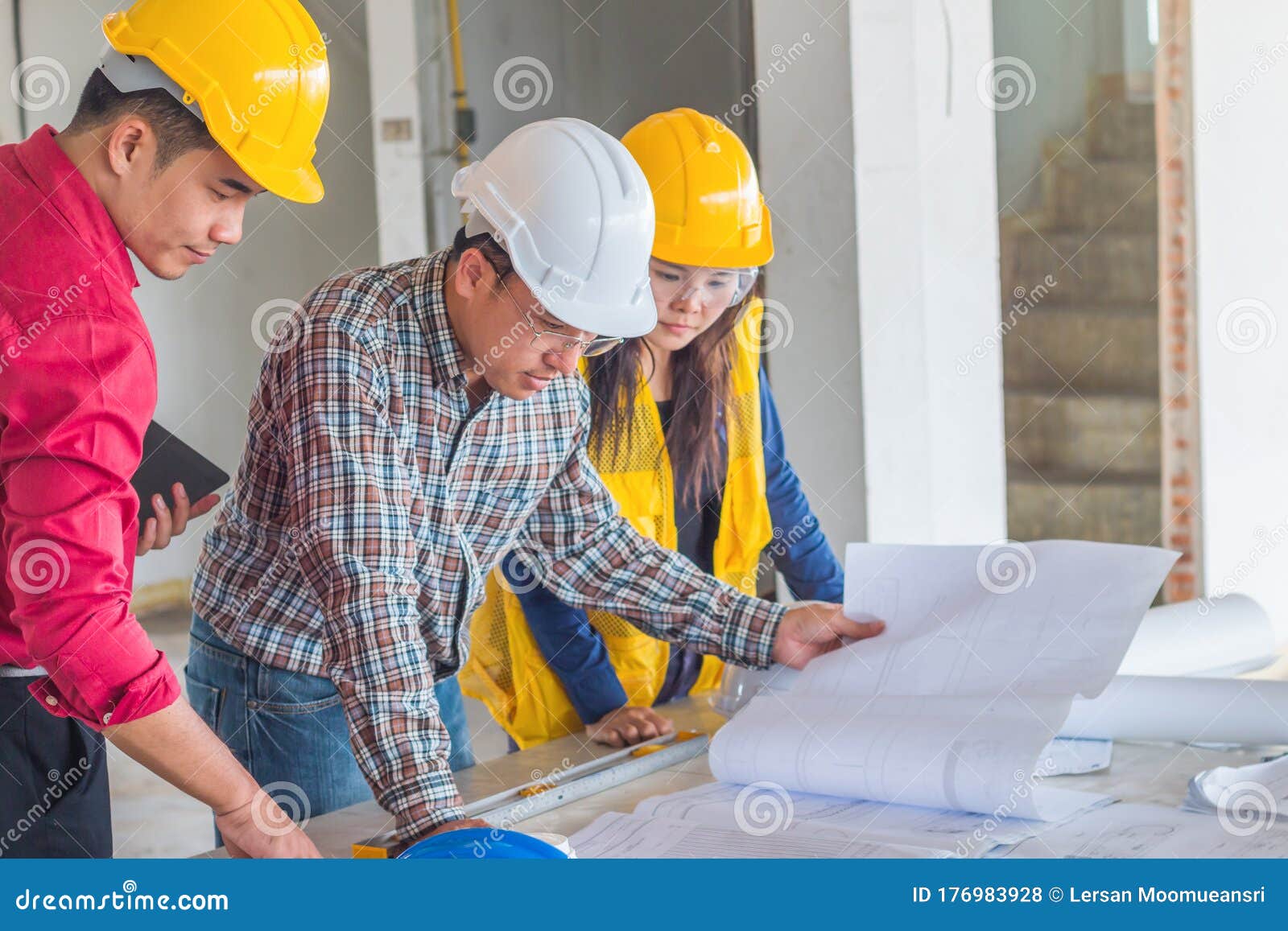 Group of Engineer Checking the Blueprint on the Table and Talking about ...