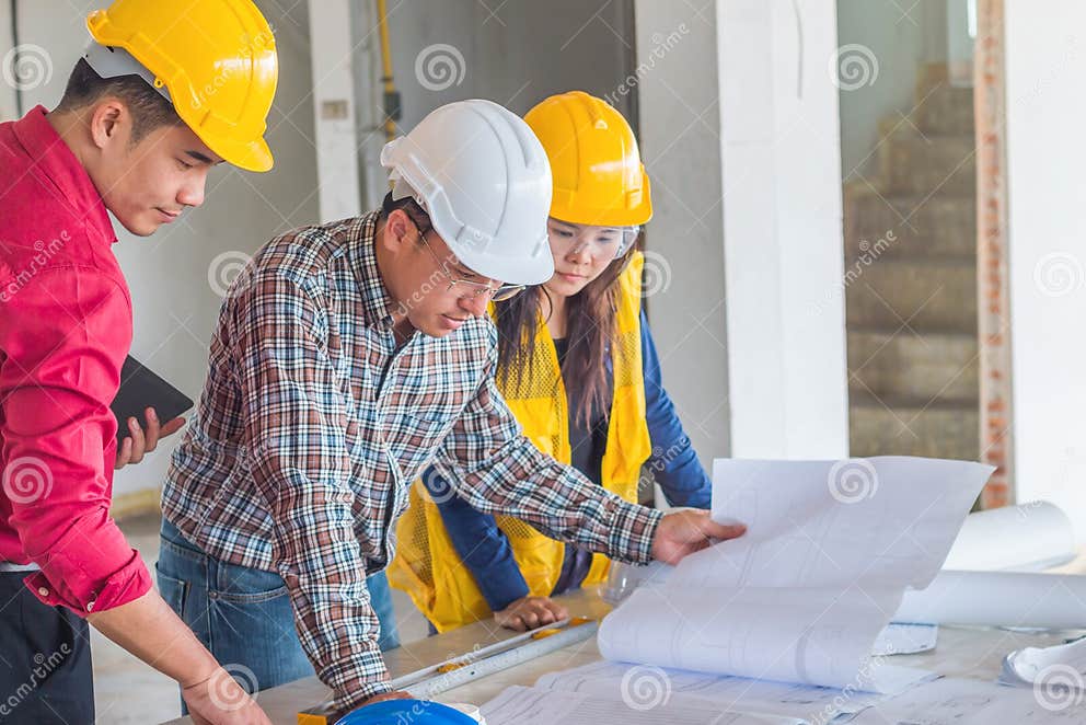 Group of Engineer Checking the Blueprint on the Table and Talking about ...