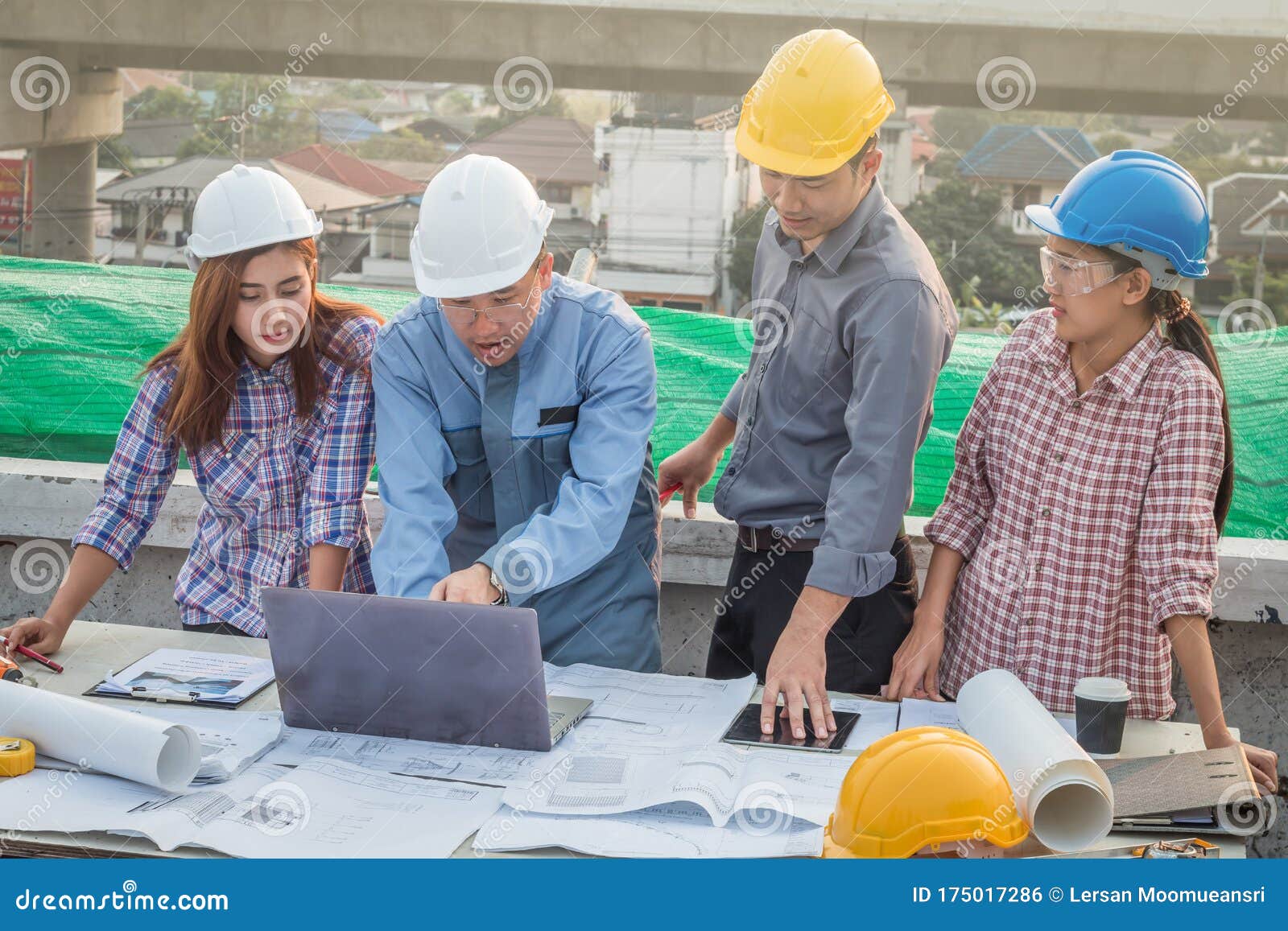 Group of Engineer Checking the Blueprint with Laptop and Talking about ...