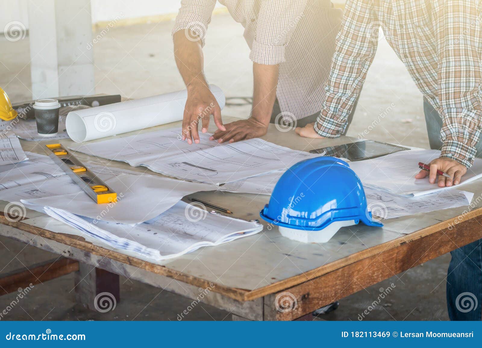 Group of Engineer Checking the Blueprint on the Table and Talking about ...