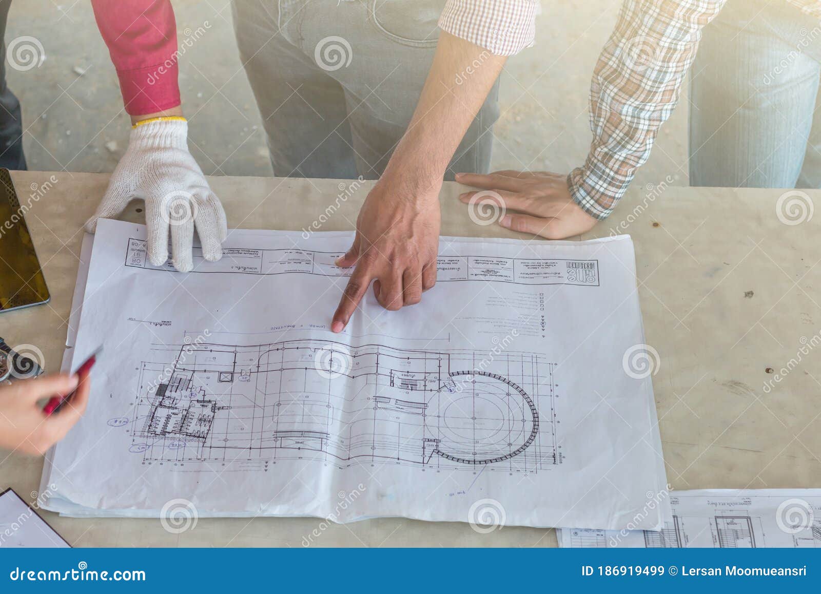 Group of Engineer Checking the Blueprint on the Table and Talking about ...
