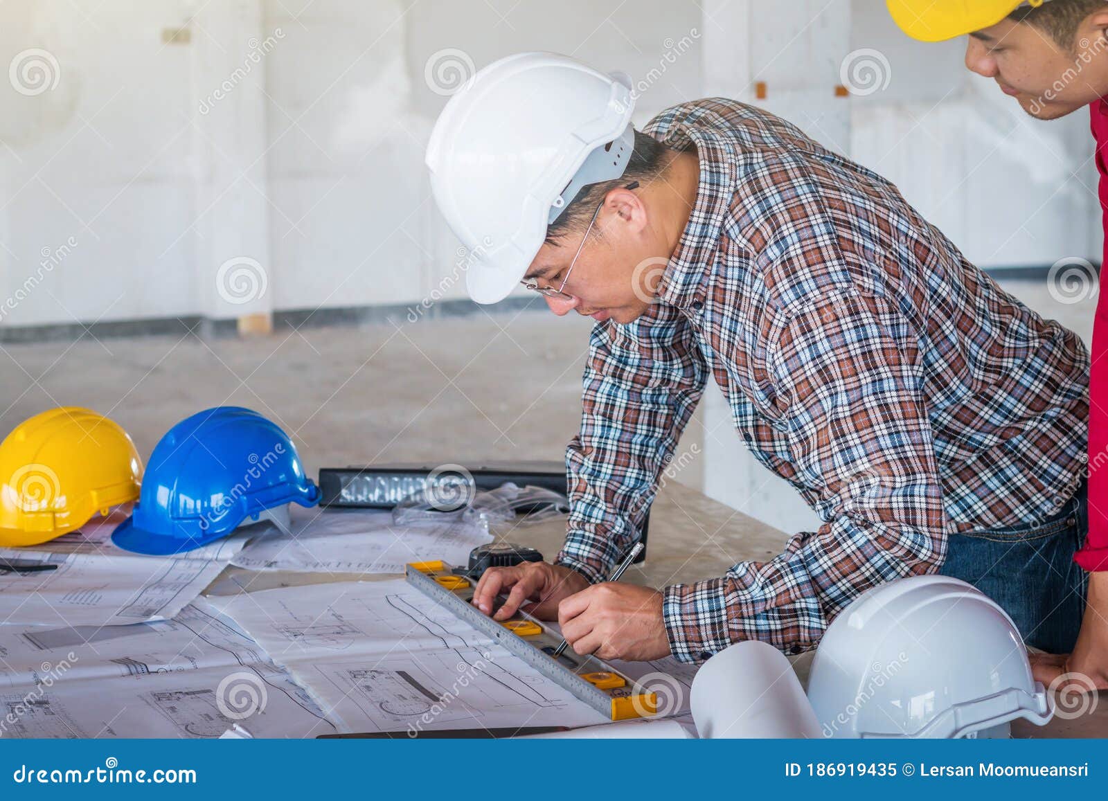 Group of Engineer Checking the Blueprint on the Table and Talking about ...