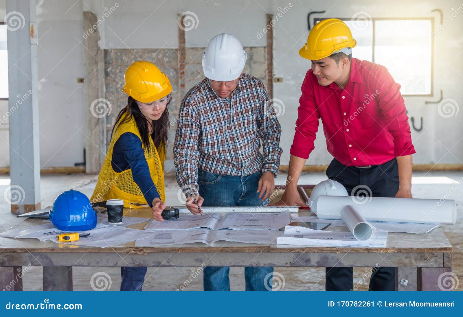 Group of Engineer Checking the Blueprint on the Table and Talking about ...