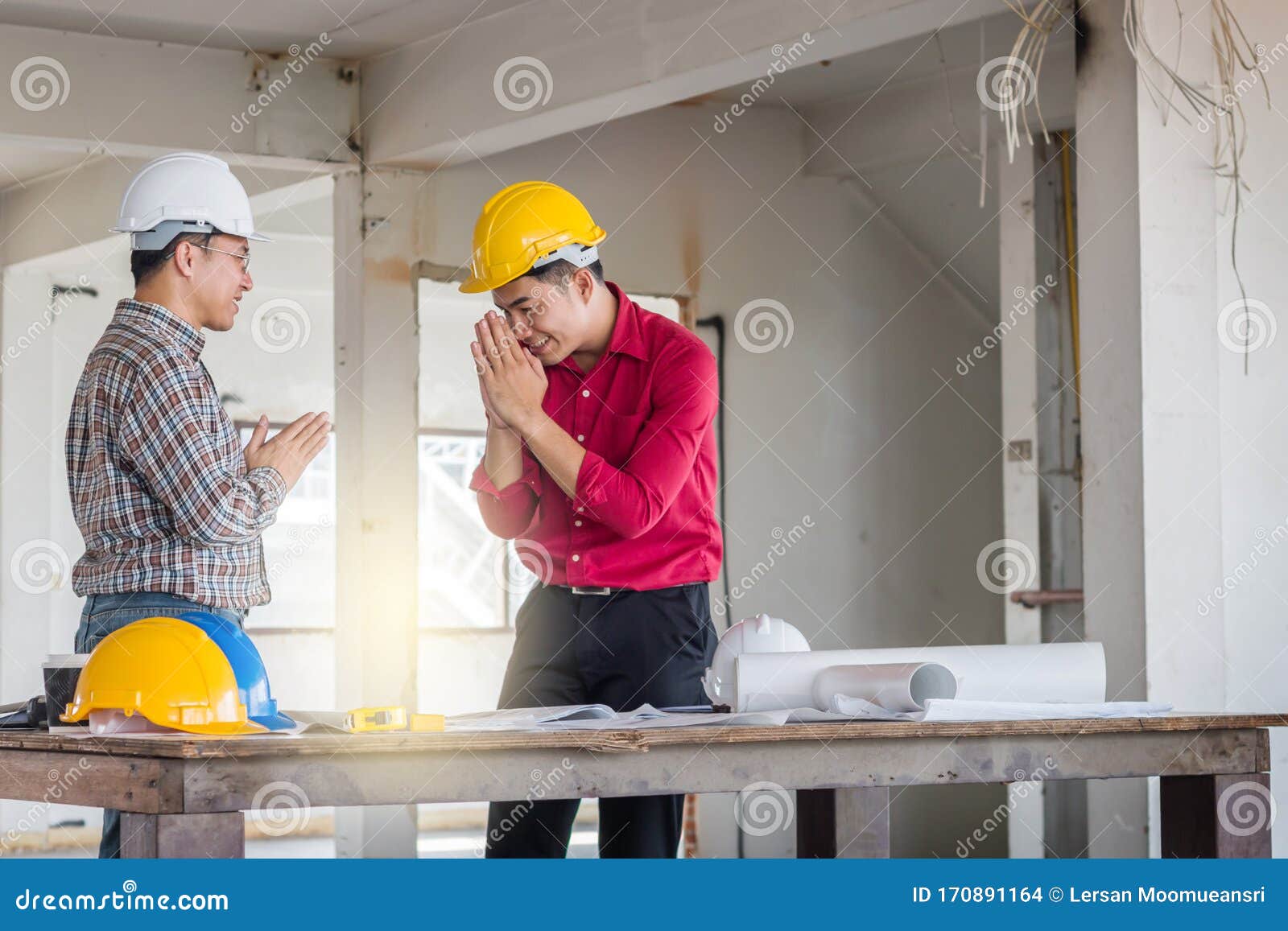 Group of Engineer Checking the Blueprint on the Table and Talking about ...