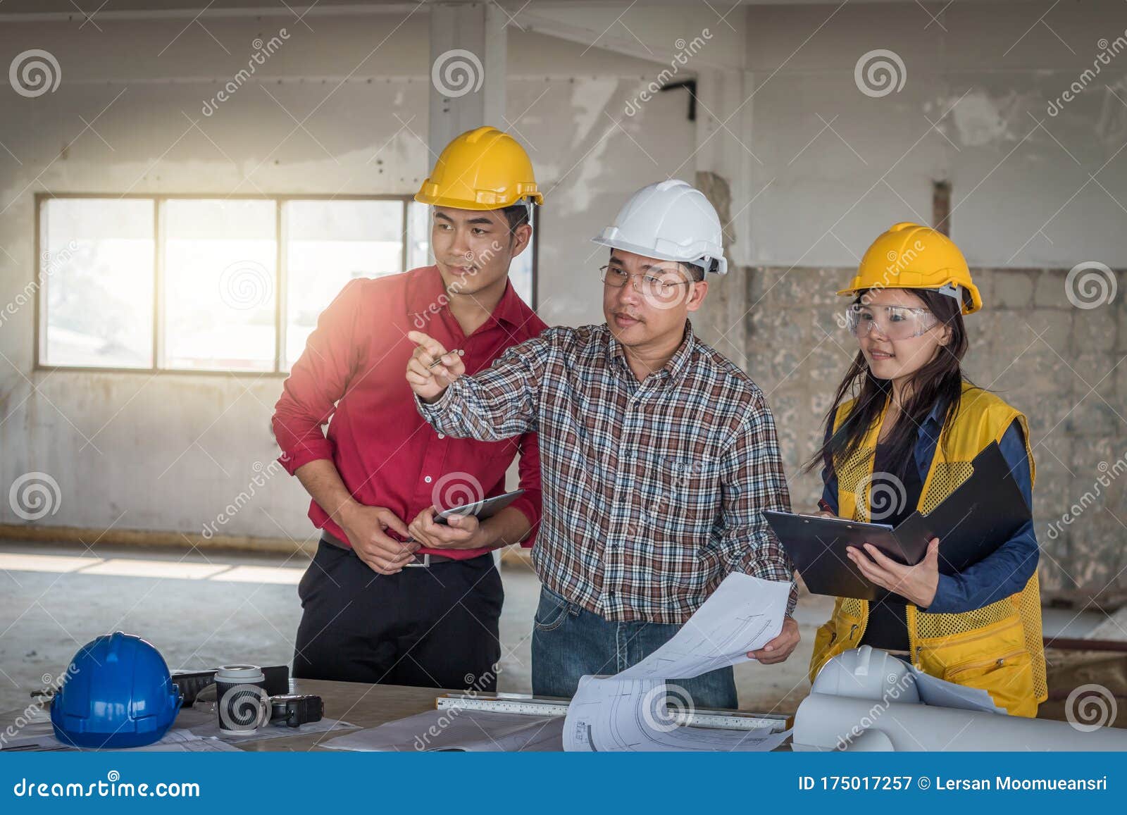 Group of Engineer Checking the Blueprint on the Table and Talking about ...