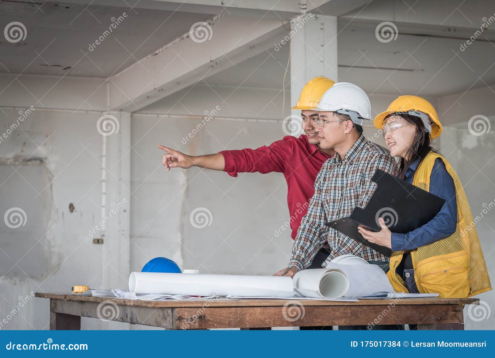 Group of Engineer Checking the Blueprint on the Table and Talking about ...