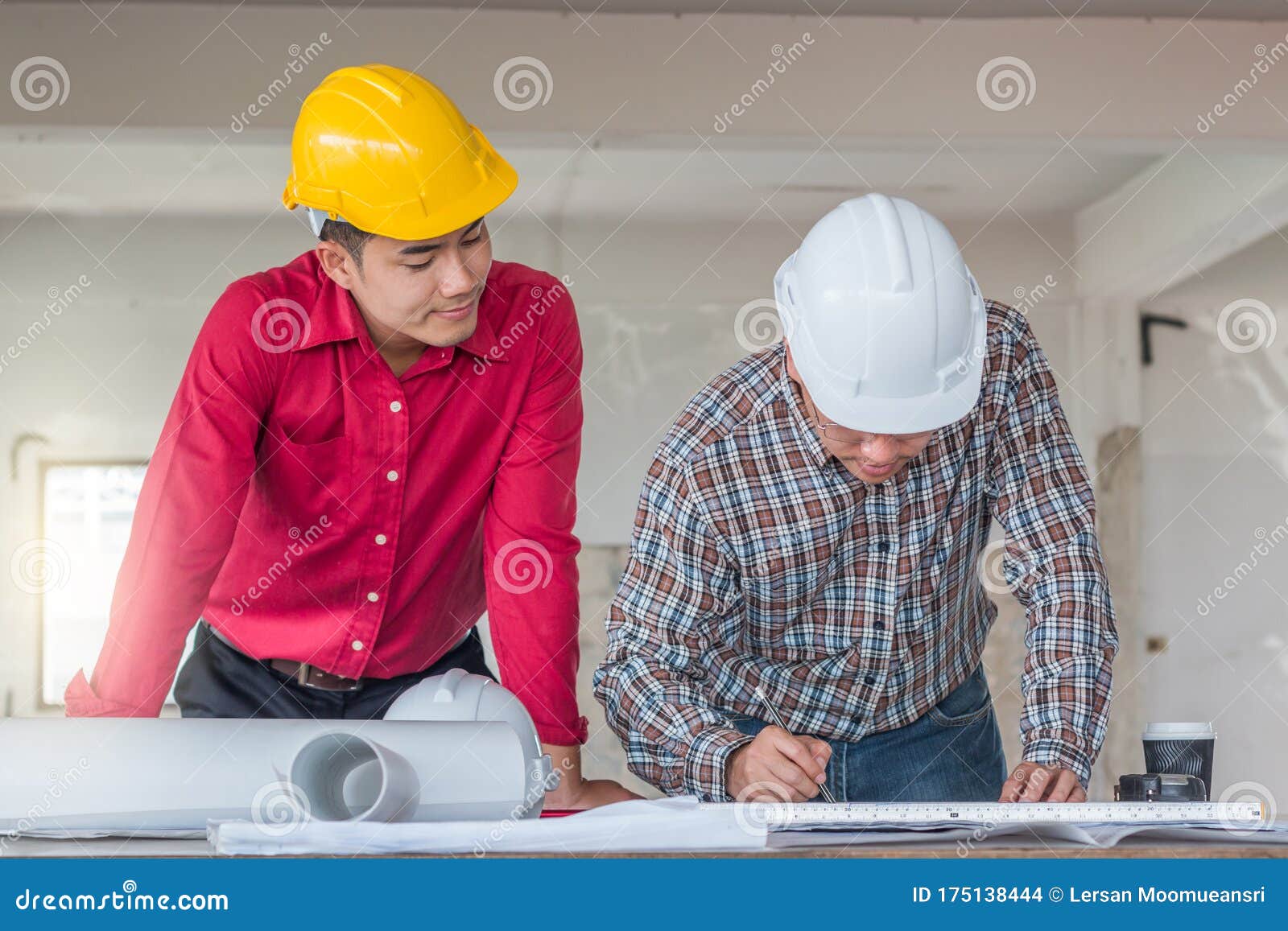 Group of Engineer Checking the Blueprint on the Table and Talking about ...