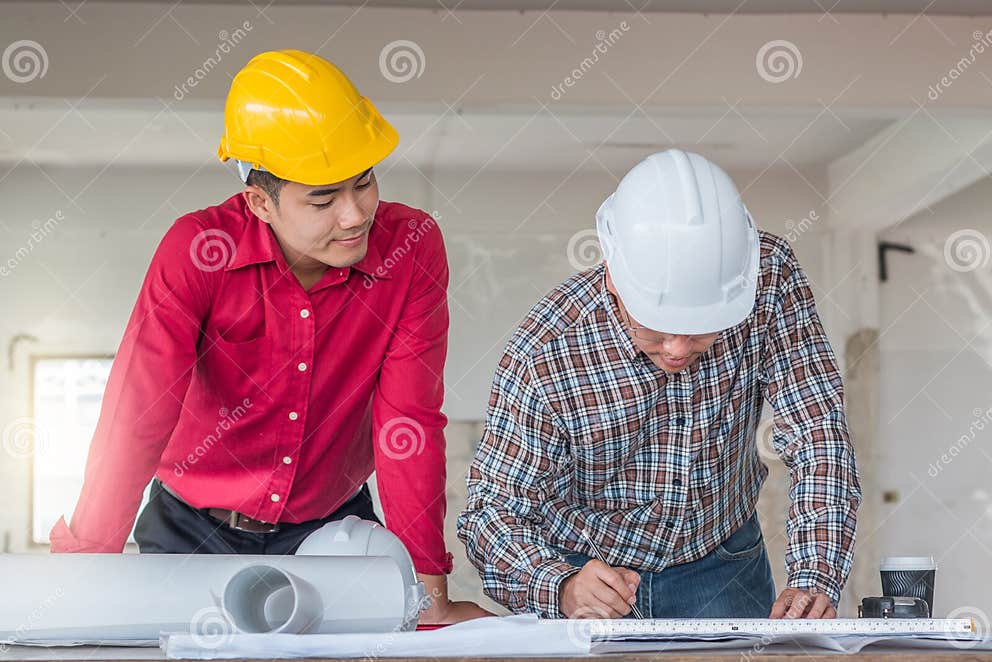 Group of Engineer Checking the Blueprint on the Table and Talking about ...