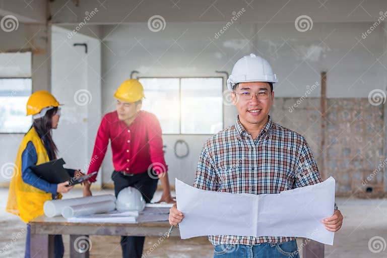 Group of Engineer Checking the Blueprint on the Table and Talking about ...