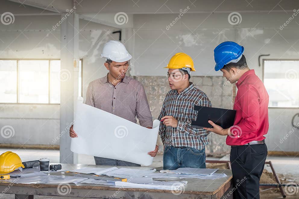 Group of Engineer Checking the Blueprint on the Table and Talking about ...
