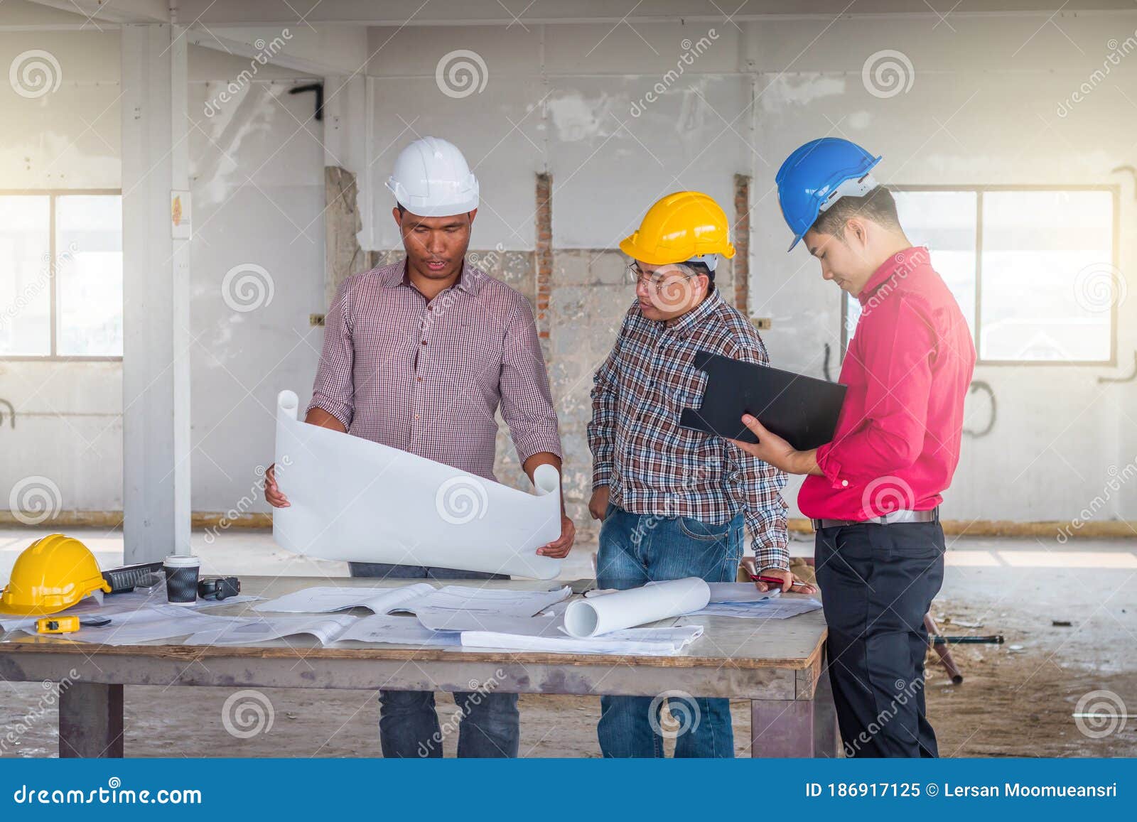 Group of Engineer Checking the Blueprint on the Table and Talking about ...