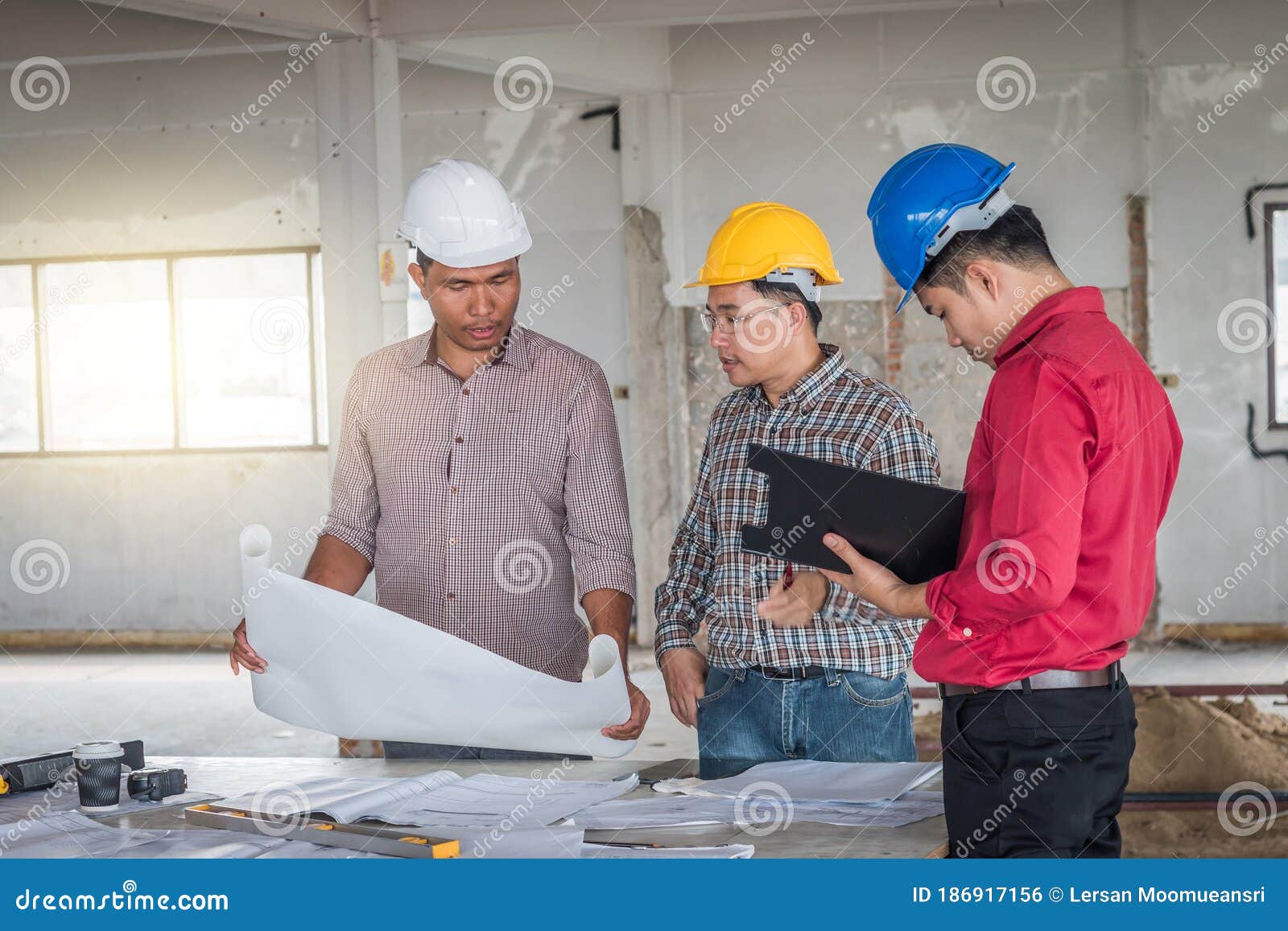 Group of Engineer Checking the Blueprint on the Table and Talking about ...