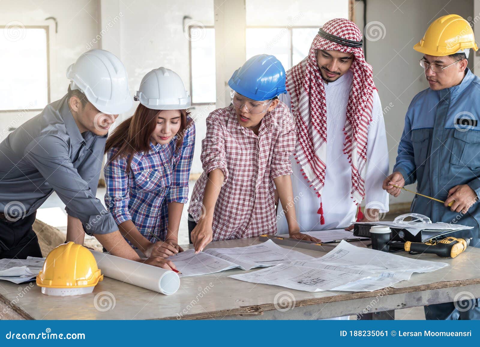 Group of Engineer Checking the Blueprint on the Table and Talking about ...
