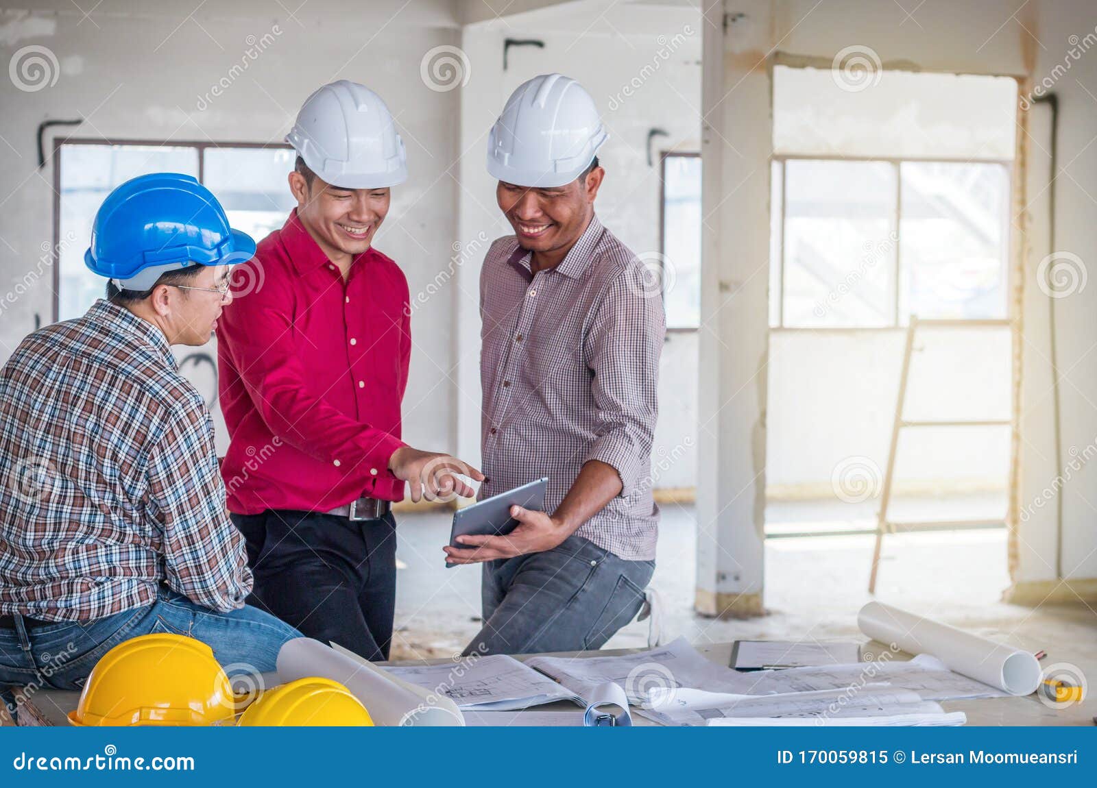 Group of Engineer Checking a Job on Tablet and Talking about ...