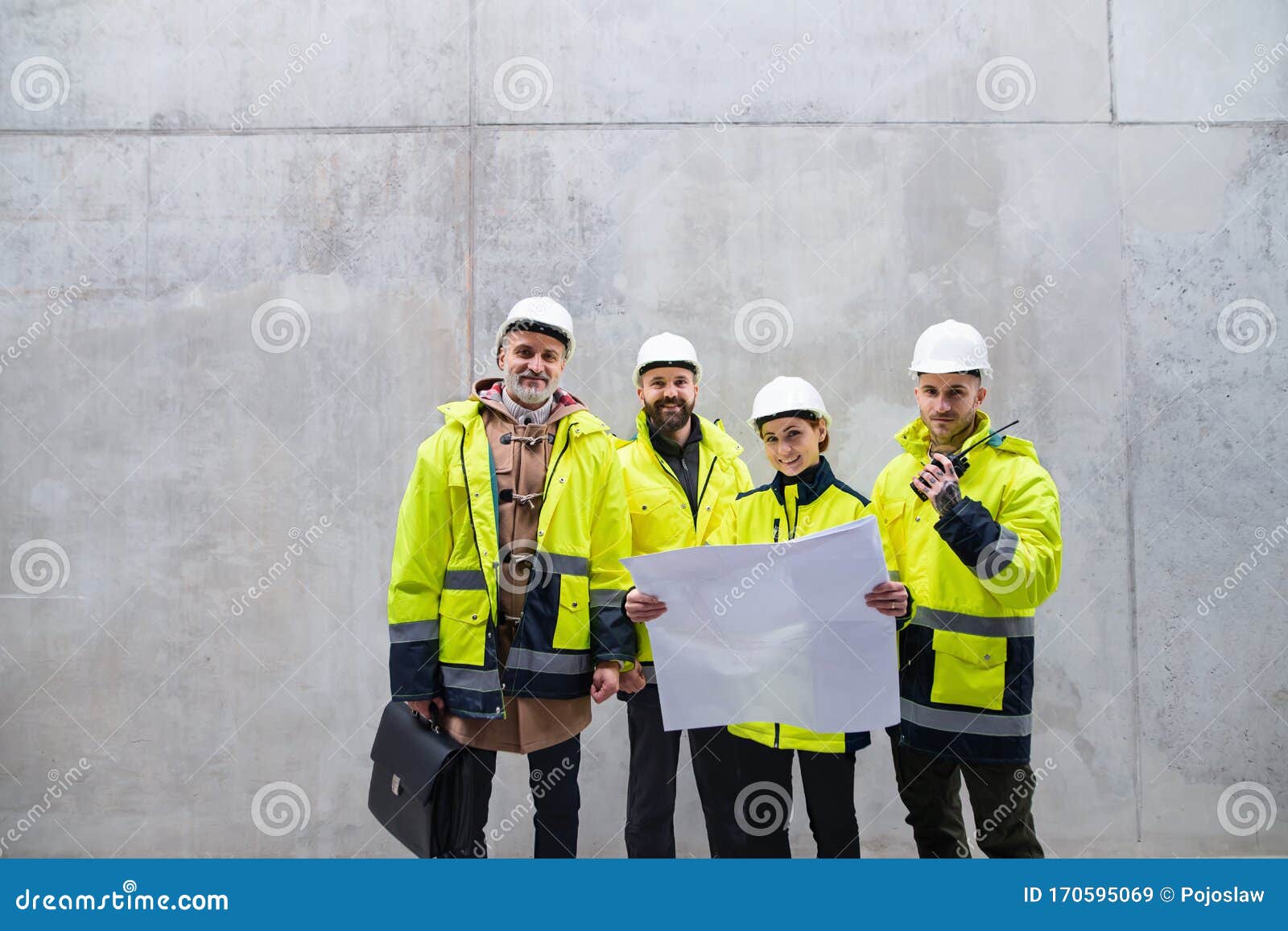 A Group of Engineers Standing Against Concrete Wall on Construction ...