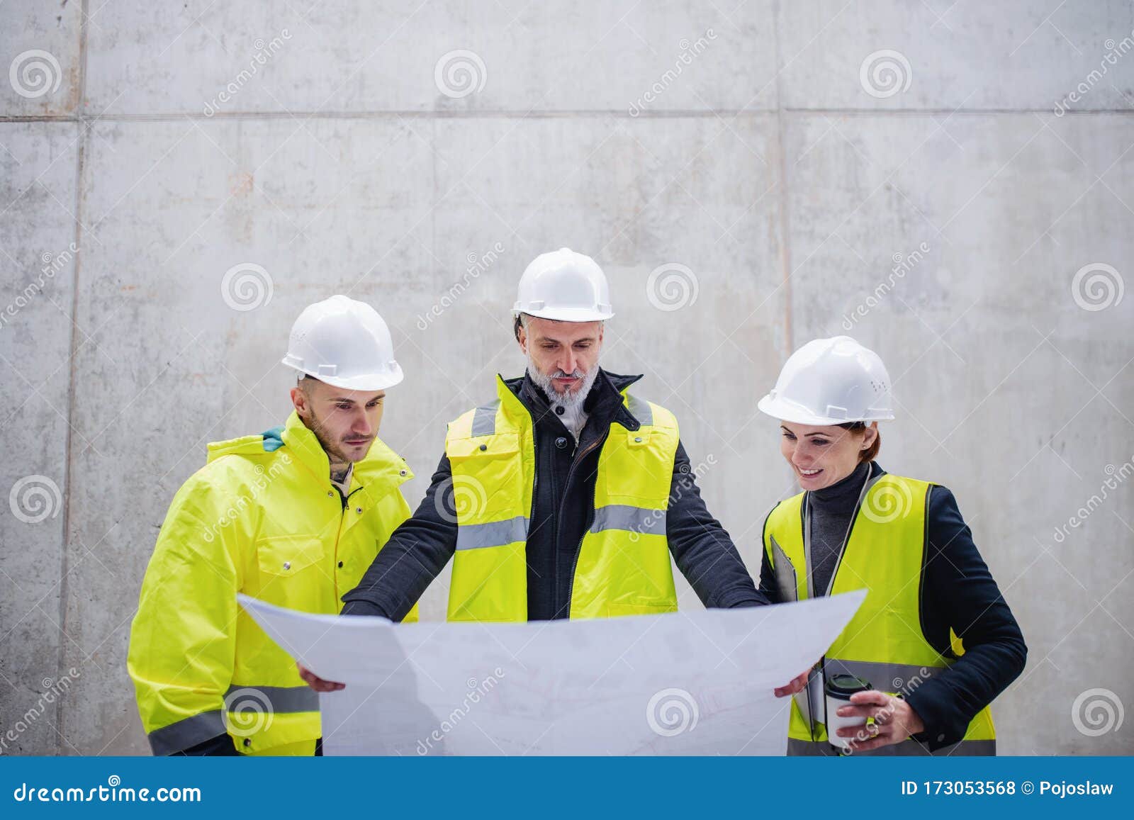 A Group of Engineers Standing Against Concrete Wall on Construction ...