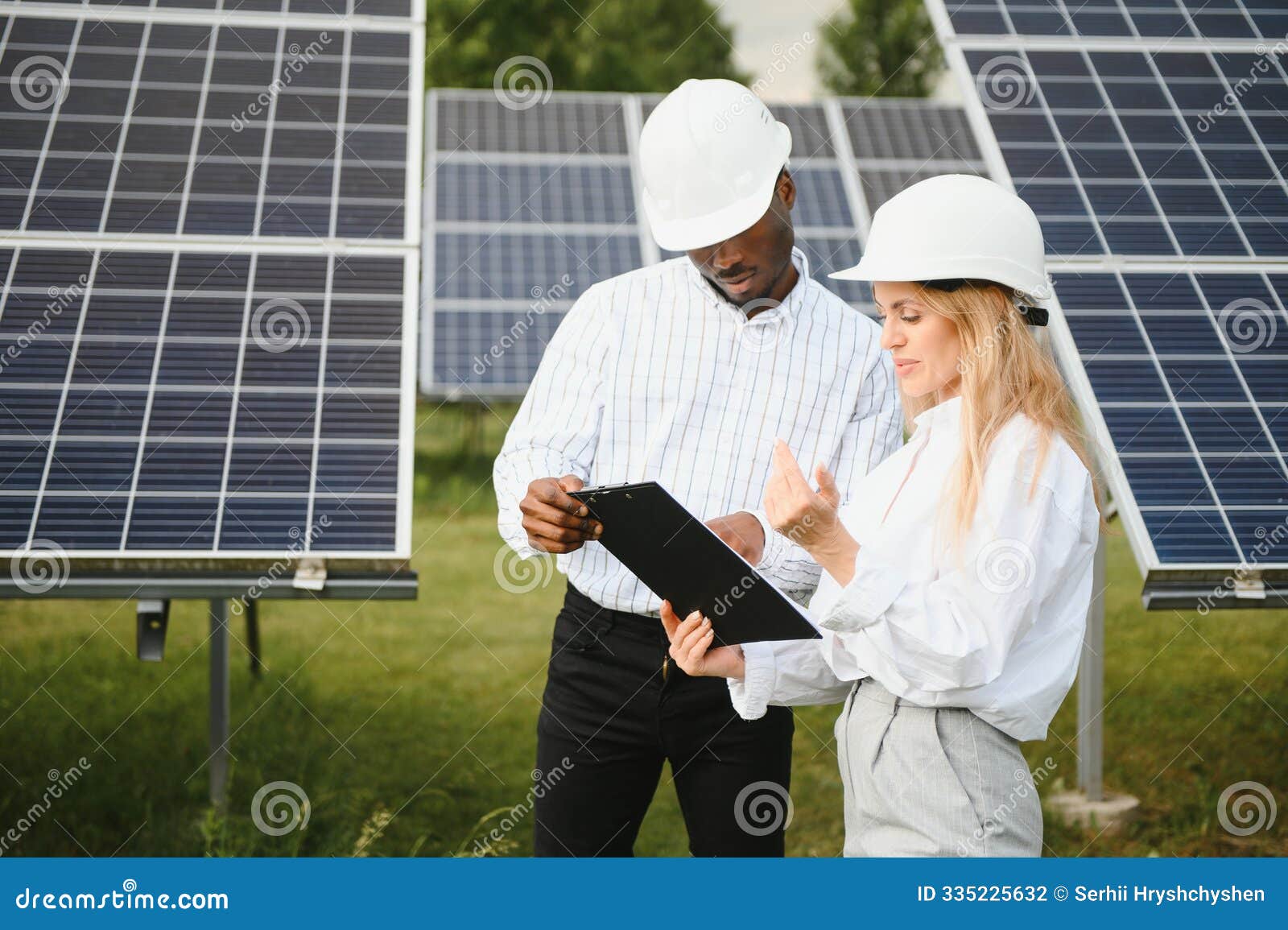 A Group of Engineers Work on a Solar Panel Farm. Stock Photo - Image of ...
