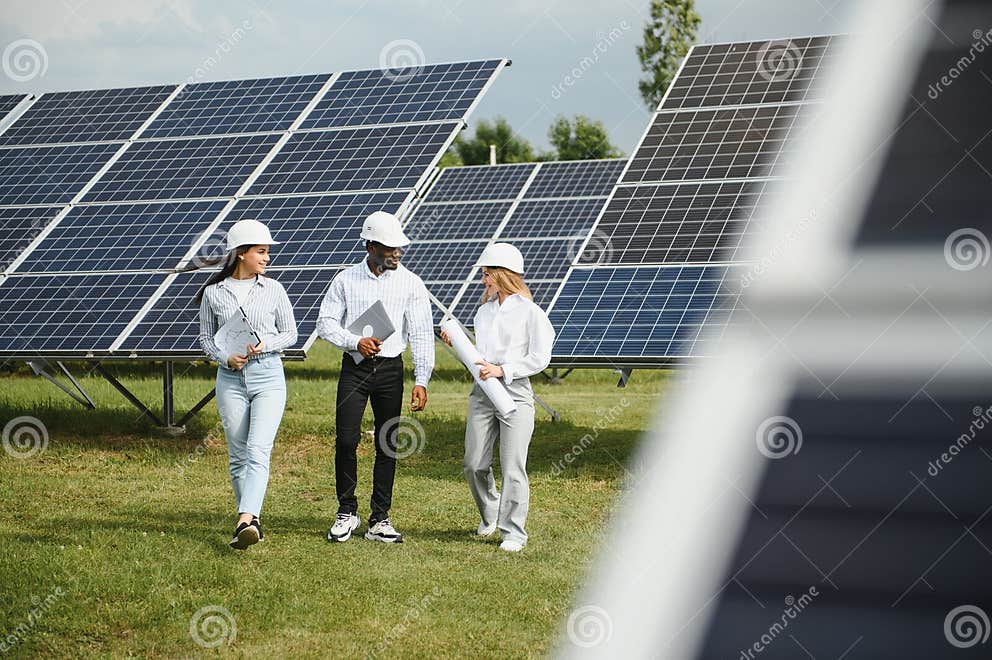 A Group of Engineers Work on a Solar Panel Farm. Stock Image - Image of ...