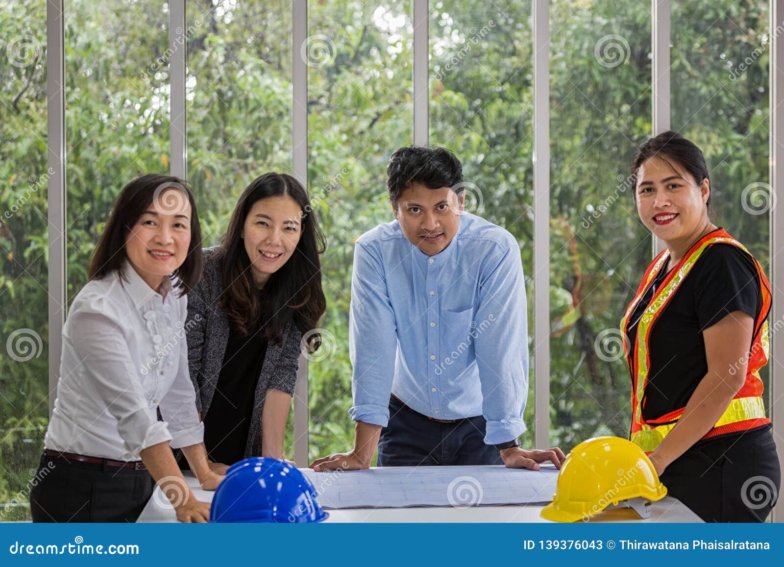 A Group Of Engineers Standing On Construction Site, Holding Blueprints ...