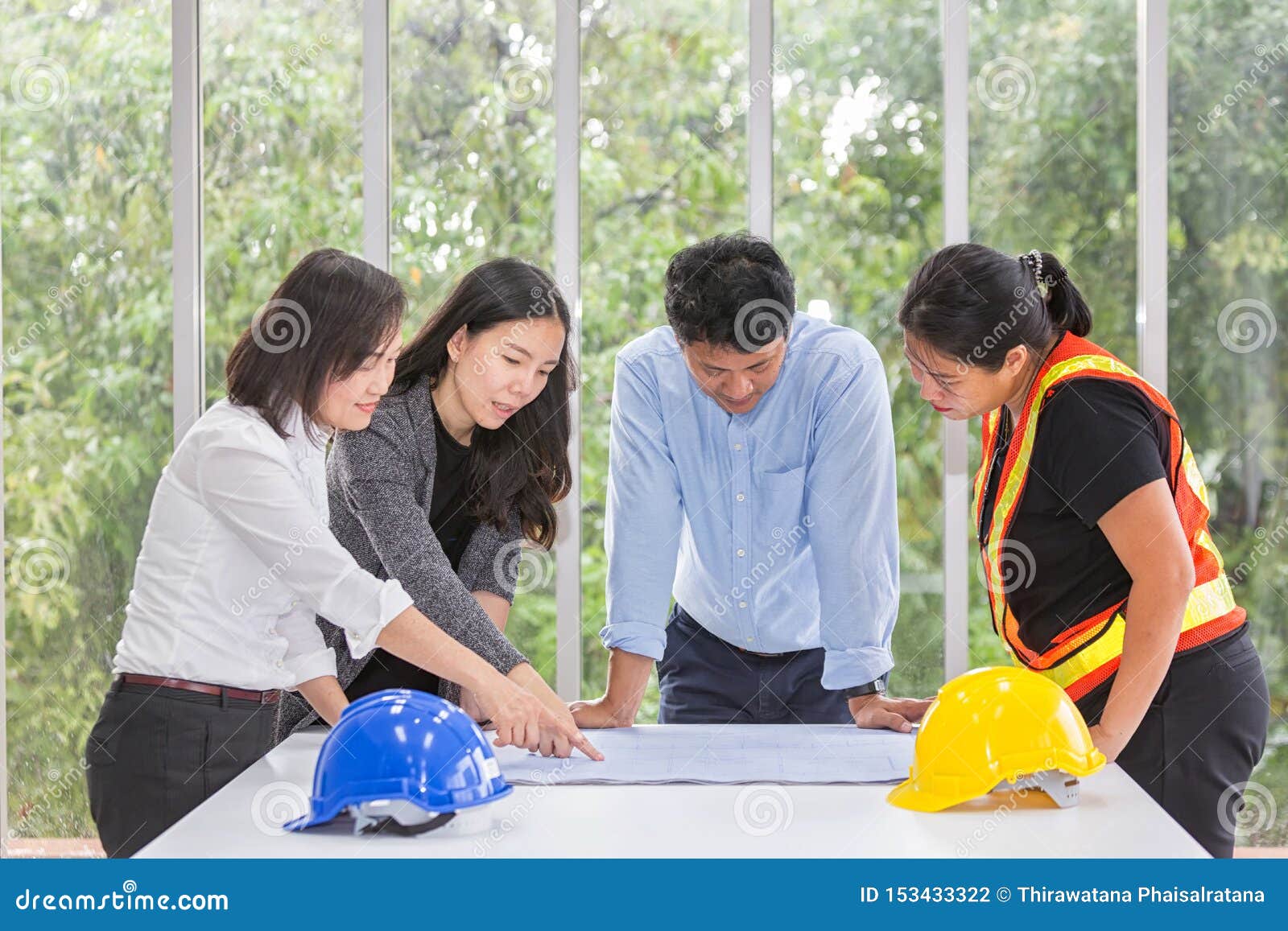 A Group Of Engineers Standing On Construction Site, Holding Blueprints ...