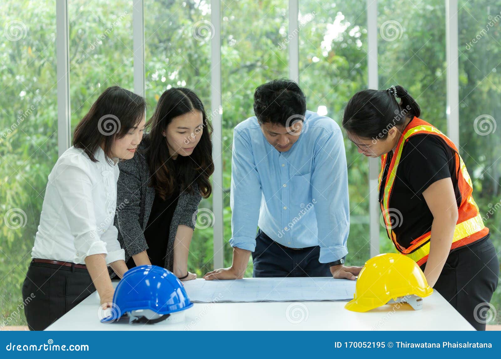 A Group Of Engineers Standing On Construction Site, Holding Blueprints ...