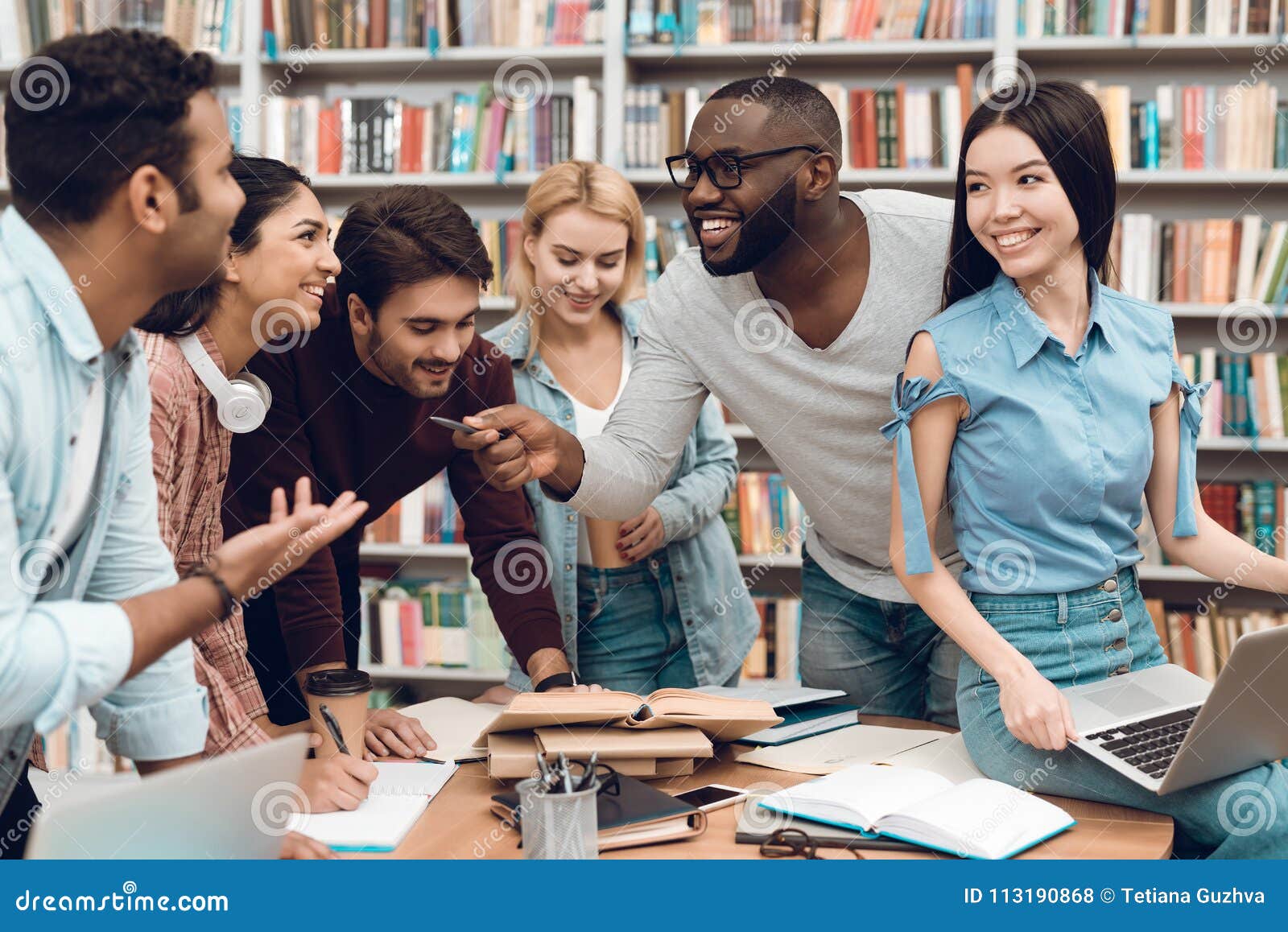 Group of Ethnic Multicultural Students Discussing Studying in Library ...