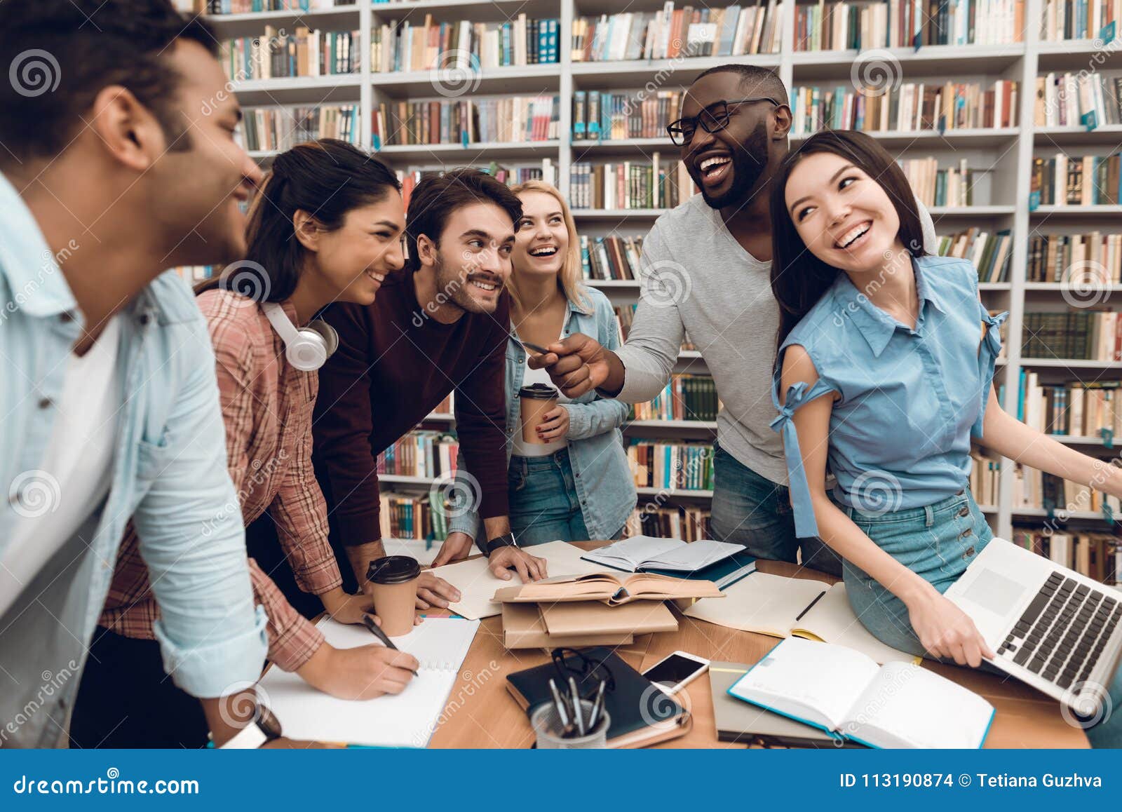 Group of Ethnic Multicultural Students Talking and Laughing in Library ...