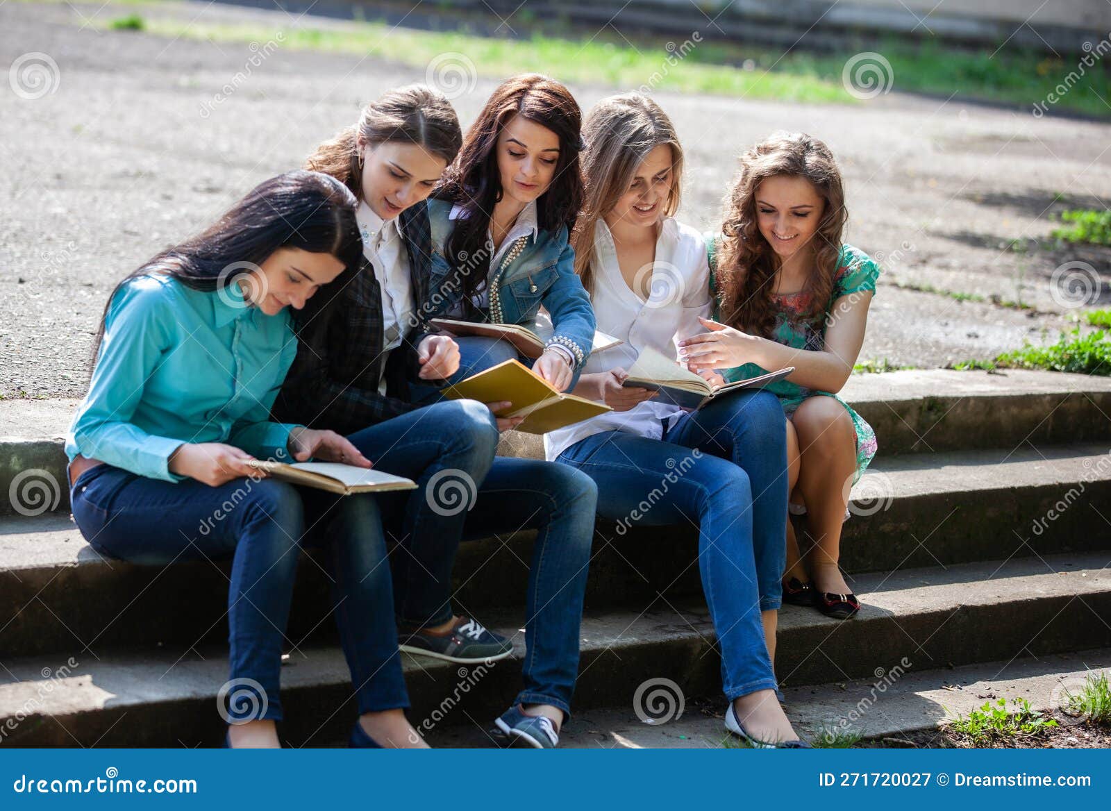 A Group of Female Students Sitting with Books in the Courtyard of the ...