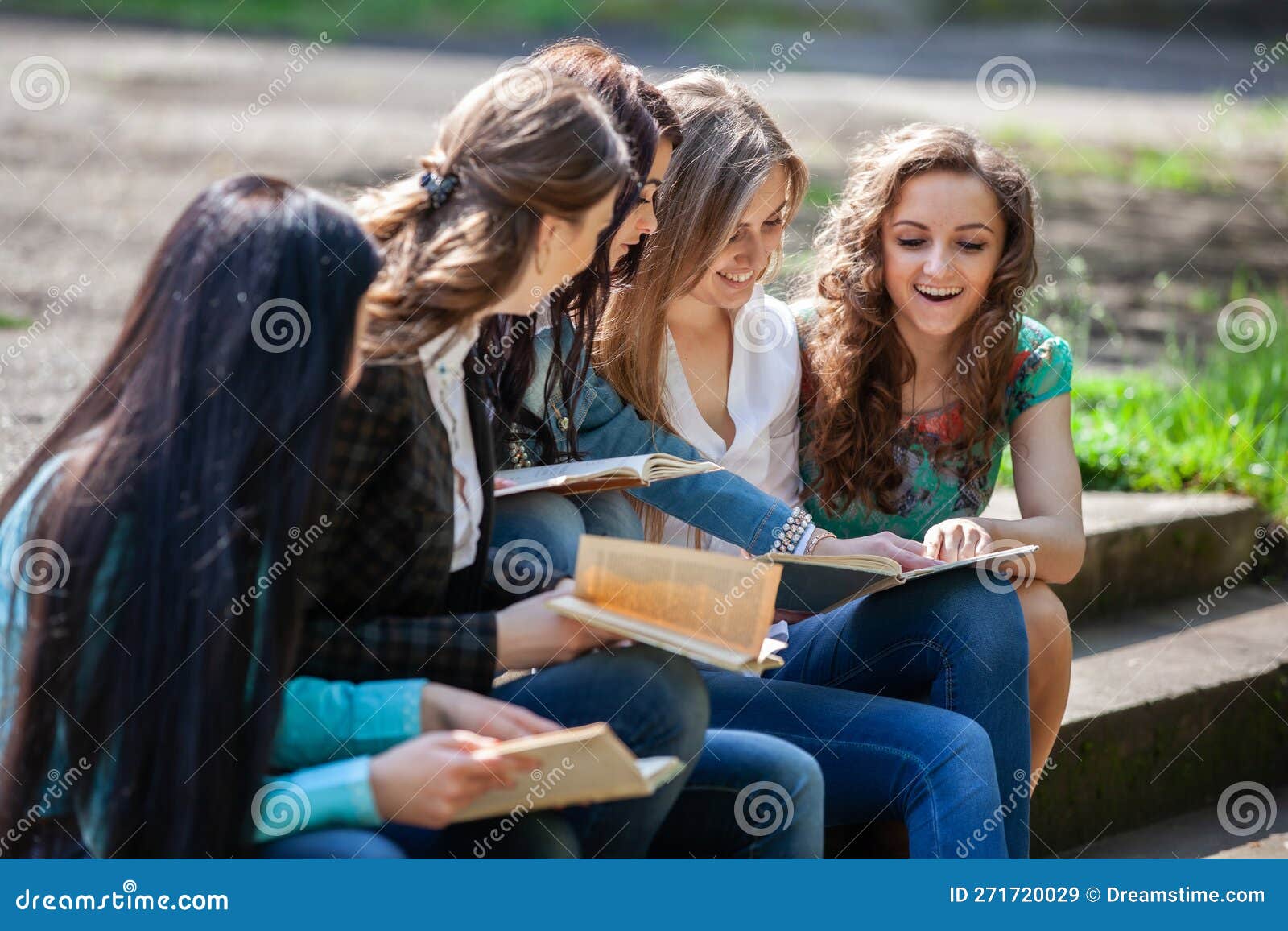 A Group of Female Students Sitting with Books in the Courtyard of the ...