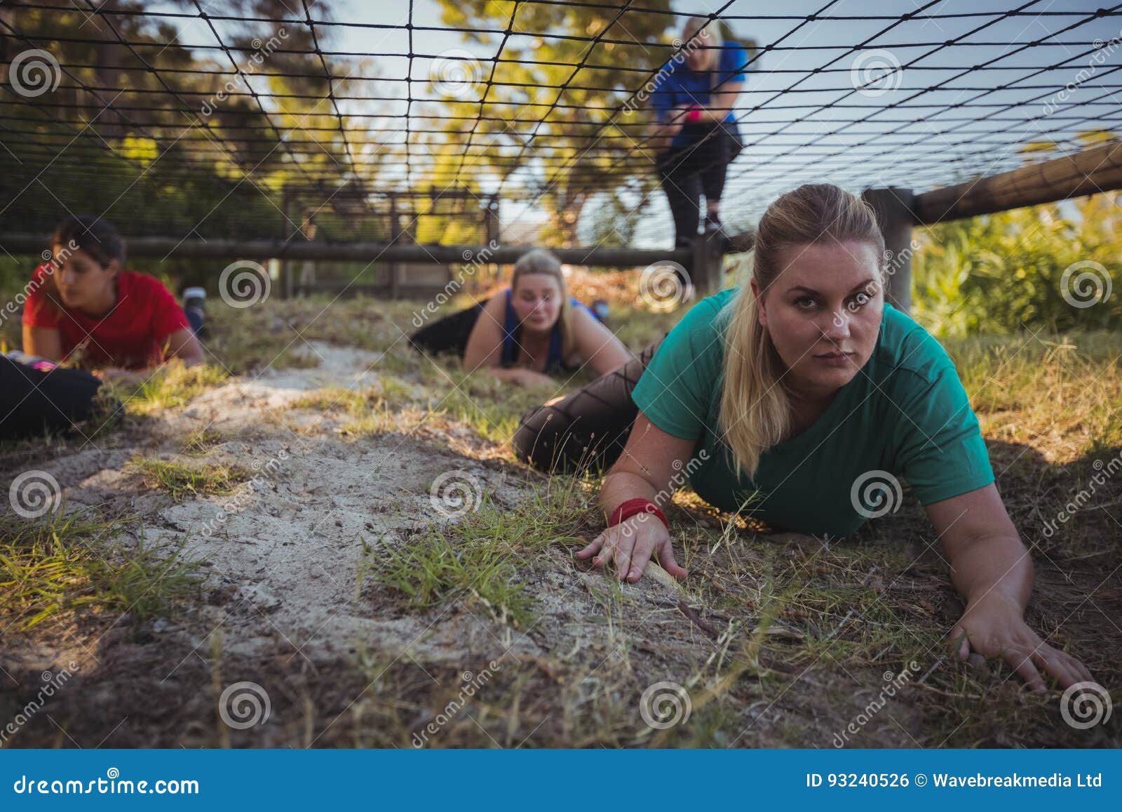 Group of Fit Women Crawling Under the Net during Obstacle Course ...