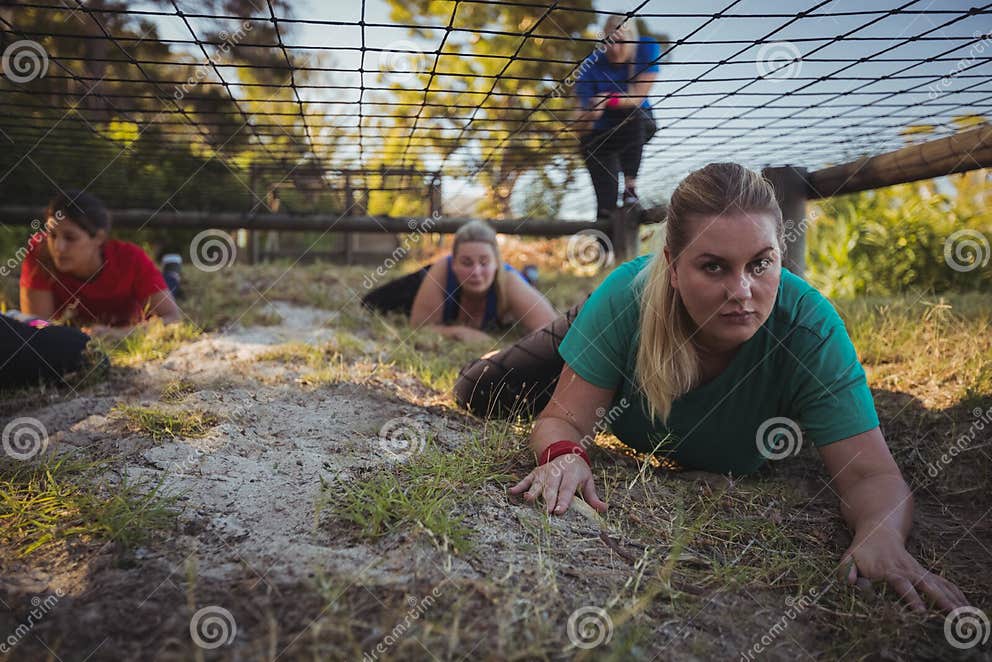 Group of Fit Women Crawling Under the Net during Obstacle Course ...