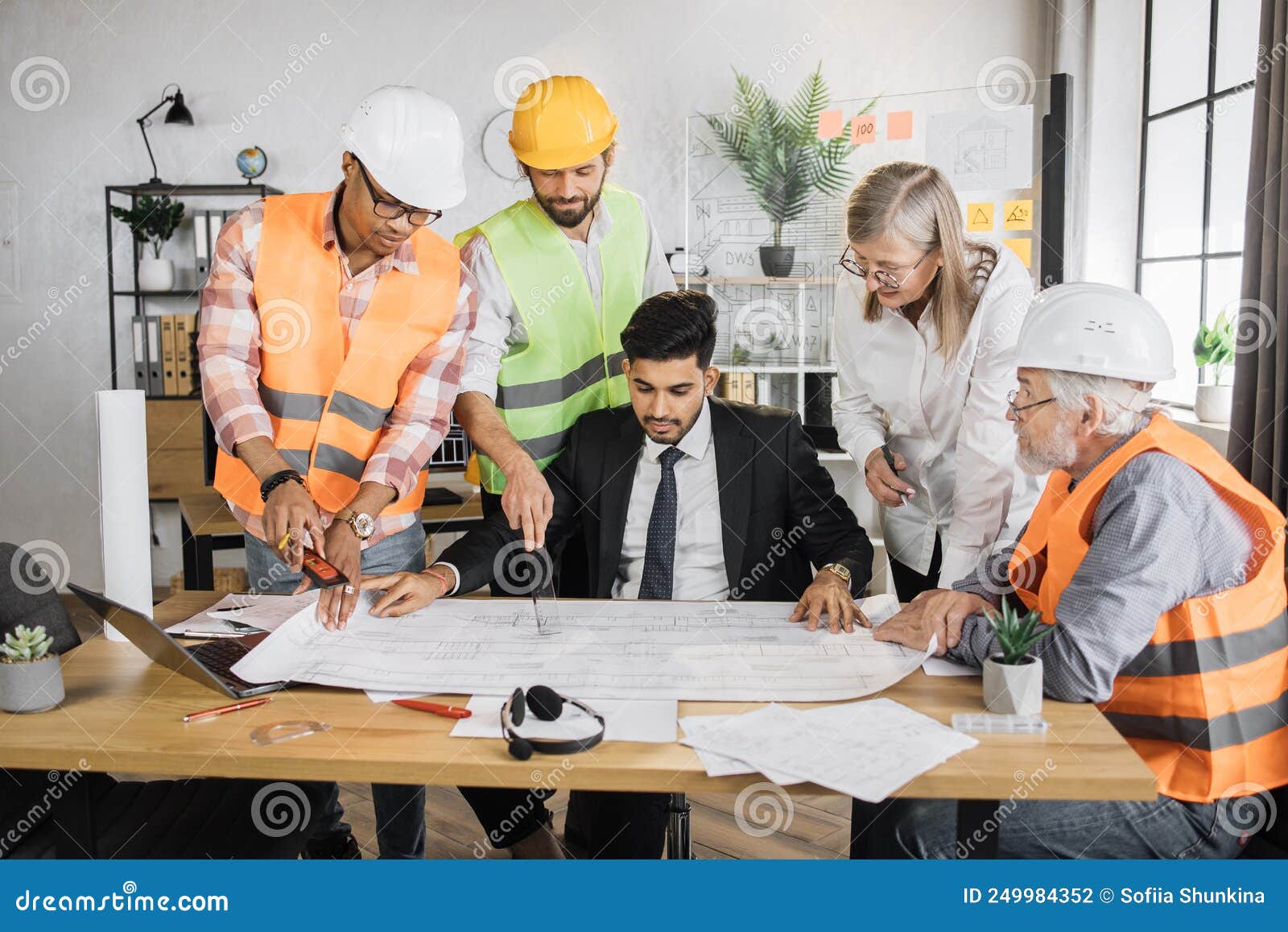 Group of Five Multiracial People in Suits and Helmets Brainstorming for ...