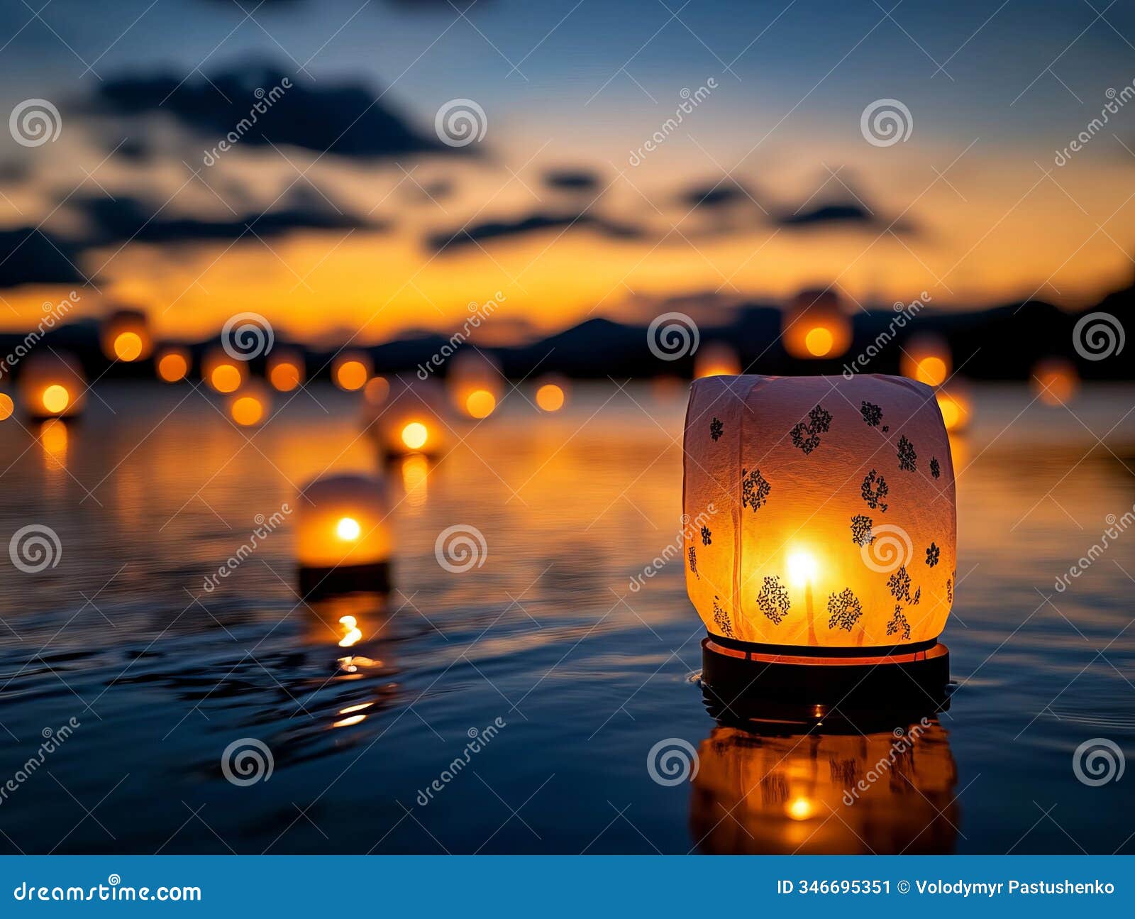 A Group of Floating Lanterns Floating in the Water at Sunset Stock ...