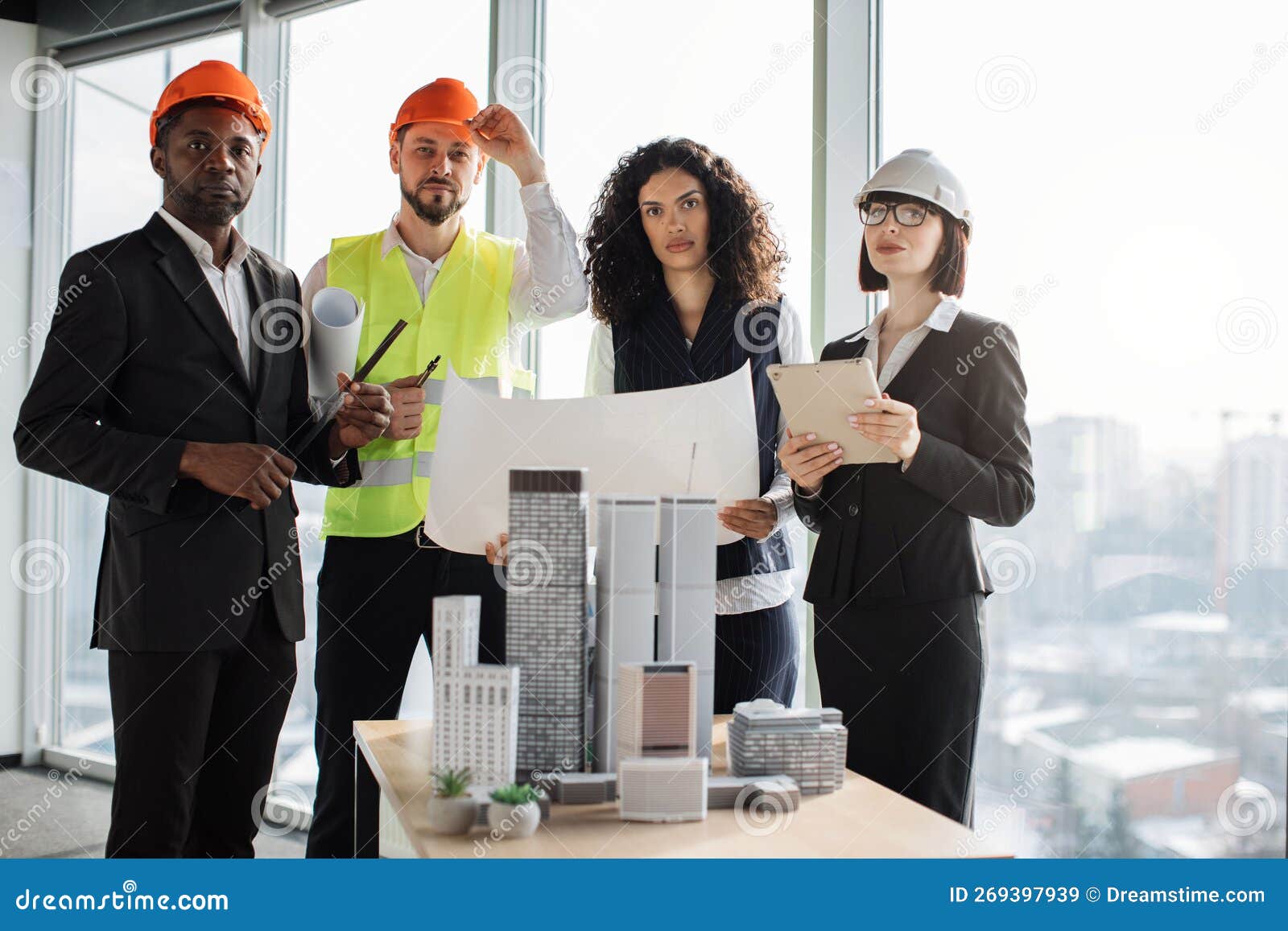 Group of Four Colleagues Standing Near Building Complex Prototype ...