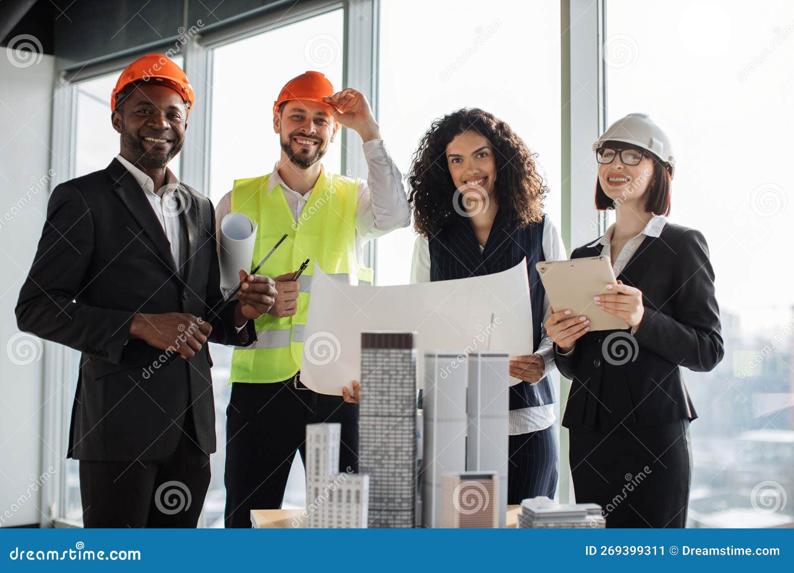Group of Four Colleagues Standing Near Building Complex Prototype ...