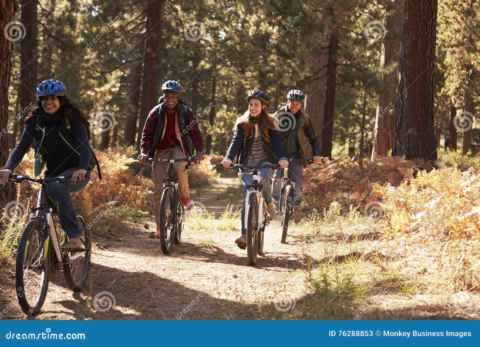 Group Four Friends in Helmets Riding Bikes on a Forest Path Stock Image ...
