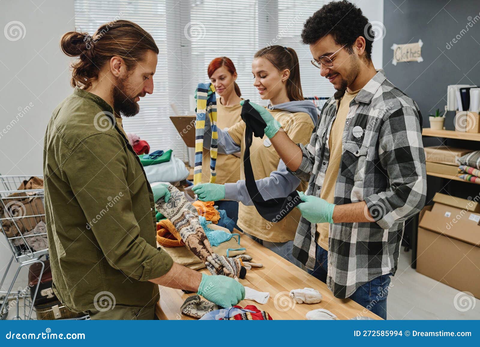 Group of Four Intercultural Volunteers Sorting Second Hand Clothes ...