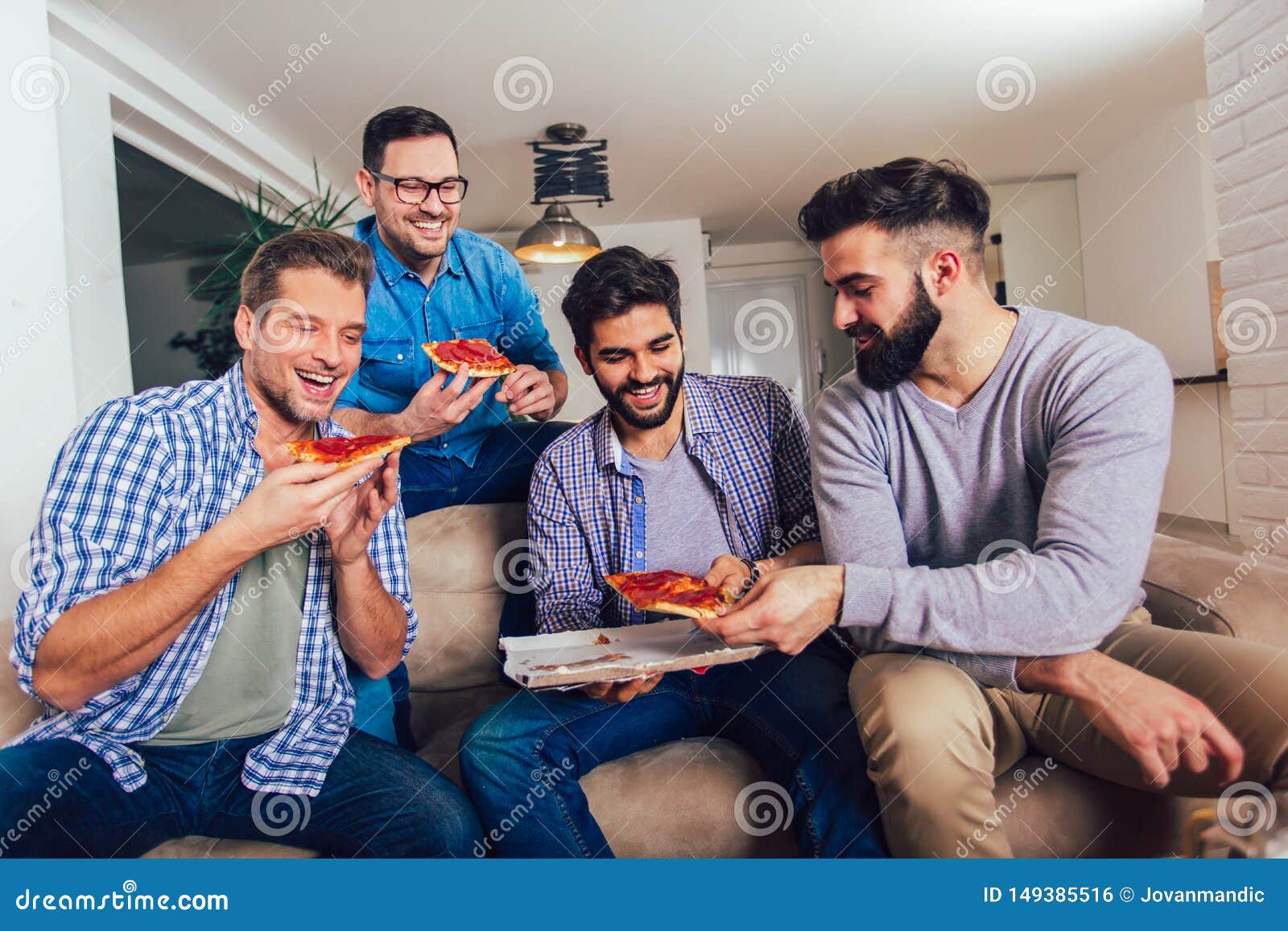Four Male Friends Eating Pizza at Home Stock Photo - Image of ...