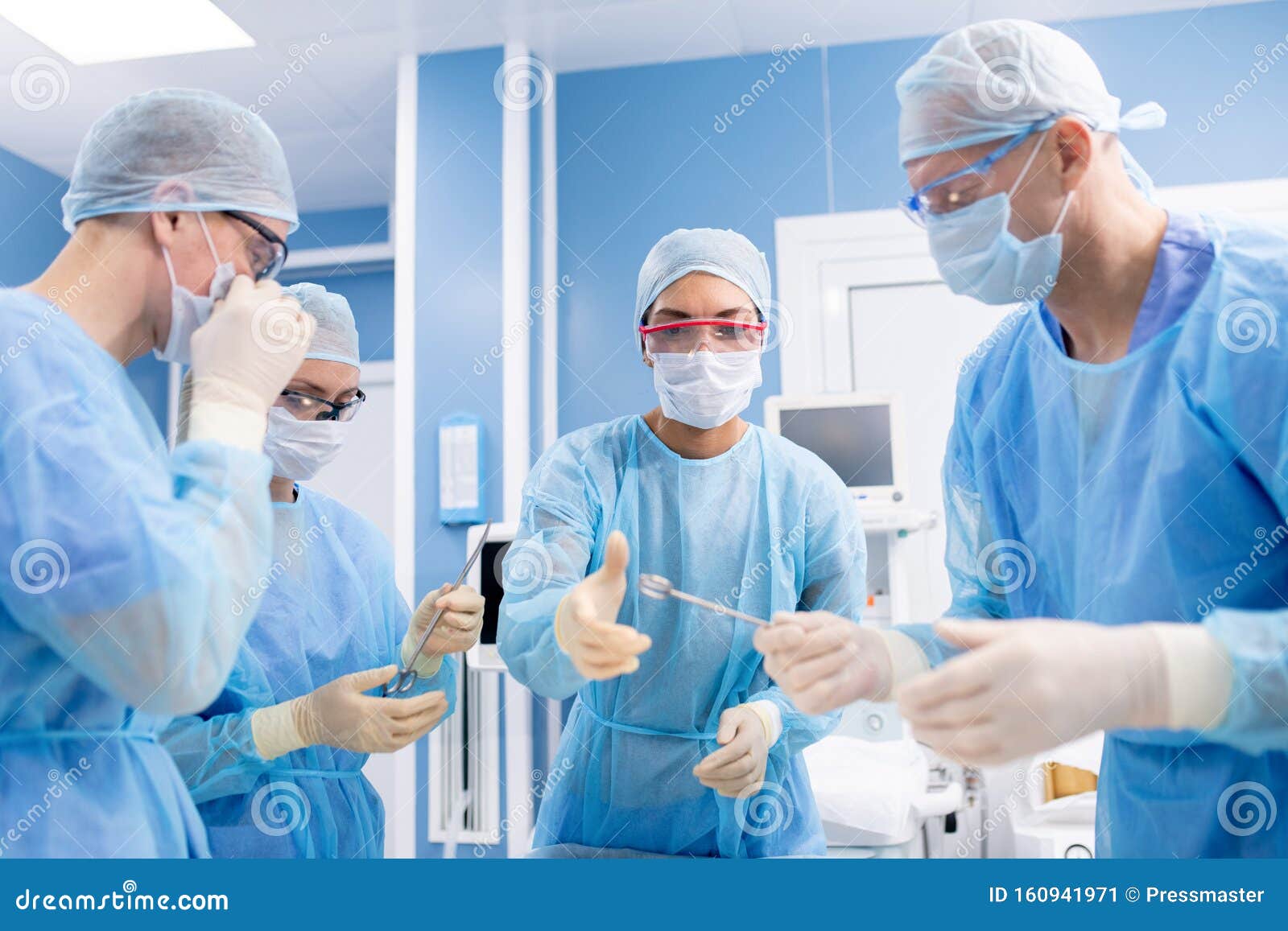 Group of Four Professionals in Protective Uniform Taking Surgical ...