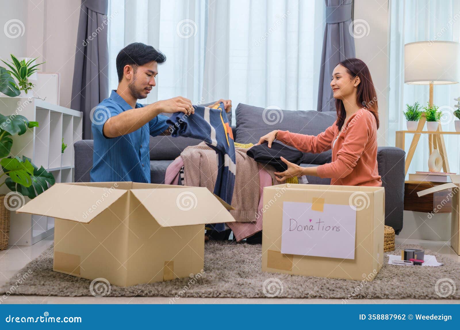 Group of Friend Sorting and Packing Clothes into a Donation Box ...