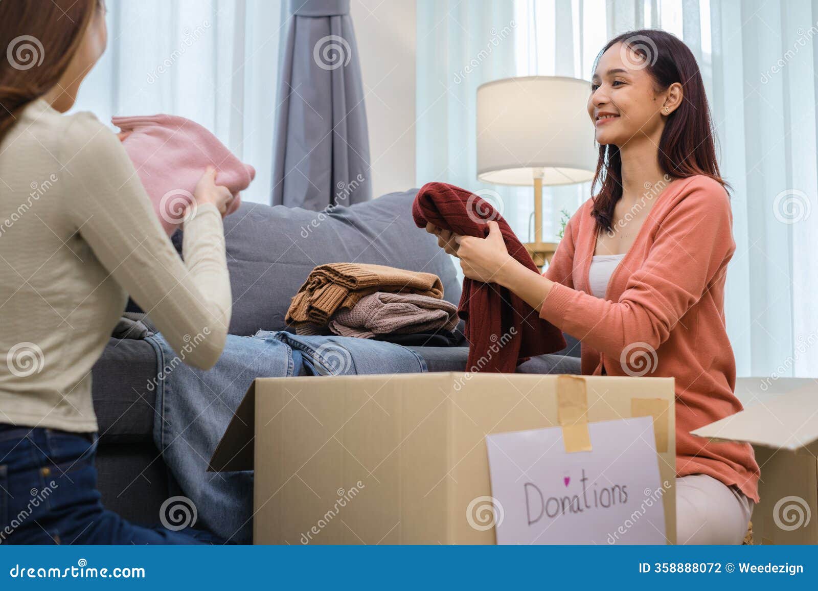 Group of Friend Sorting and Packing Clothes into a Donation Box ...