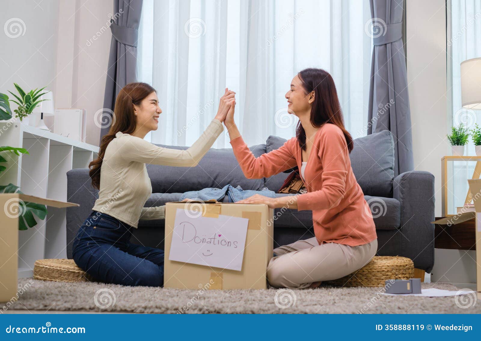 Group of Friend Sorting and Packing Clothes into a Donation Box ...