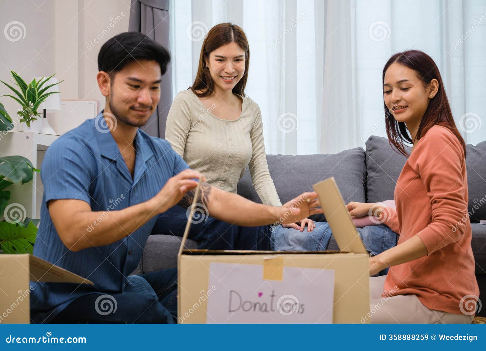 Group of Friend Sorting and Packing Clothes into a Donation Box ...