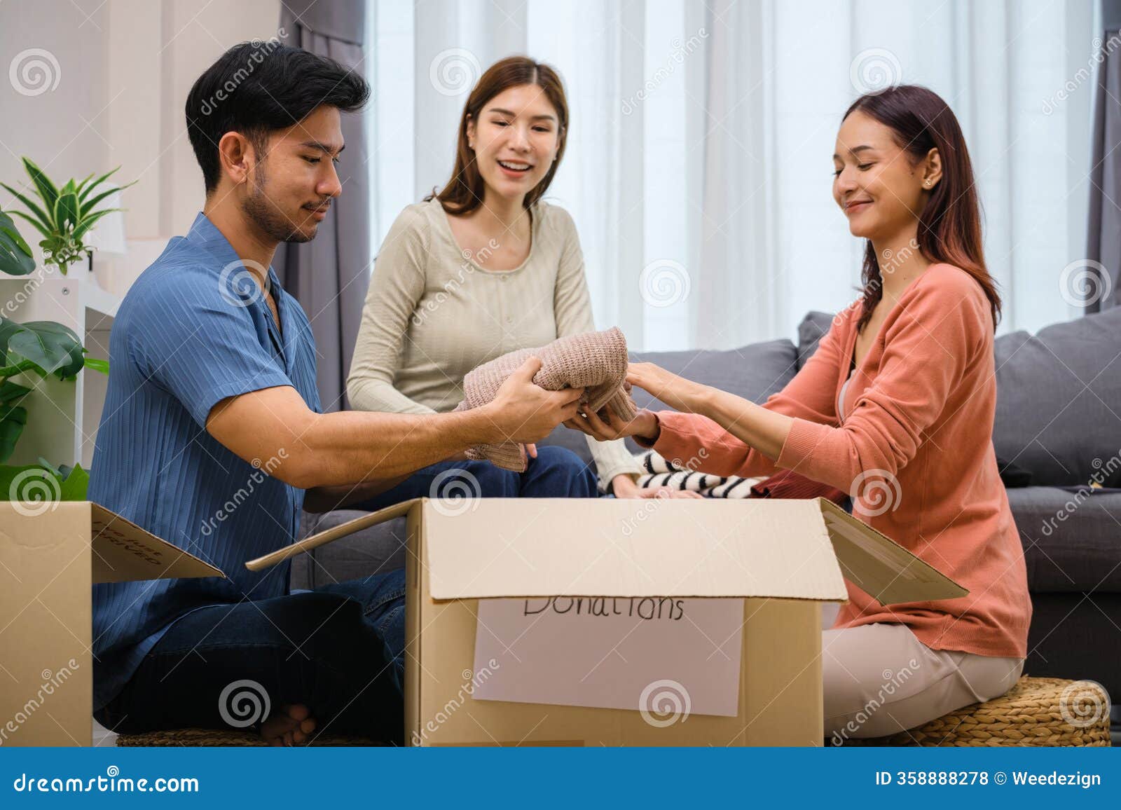 Group of Friend Sorting and Packing Clothes into a Donation Box ...